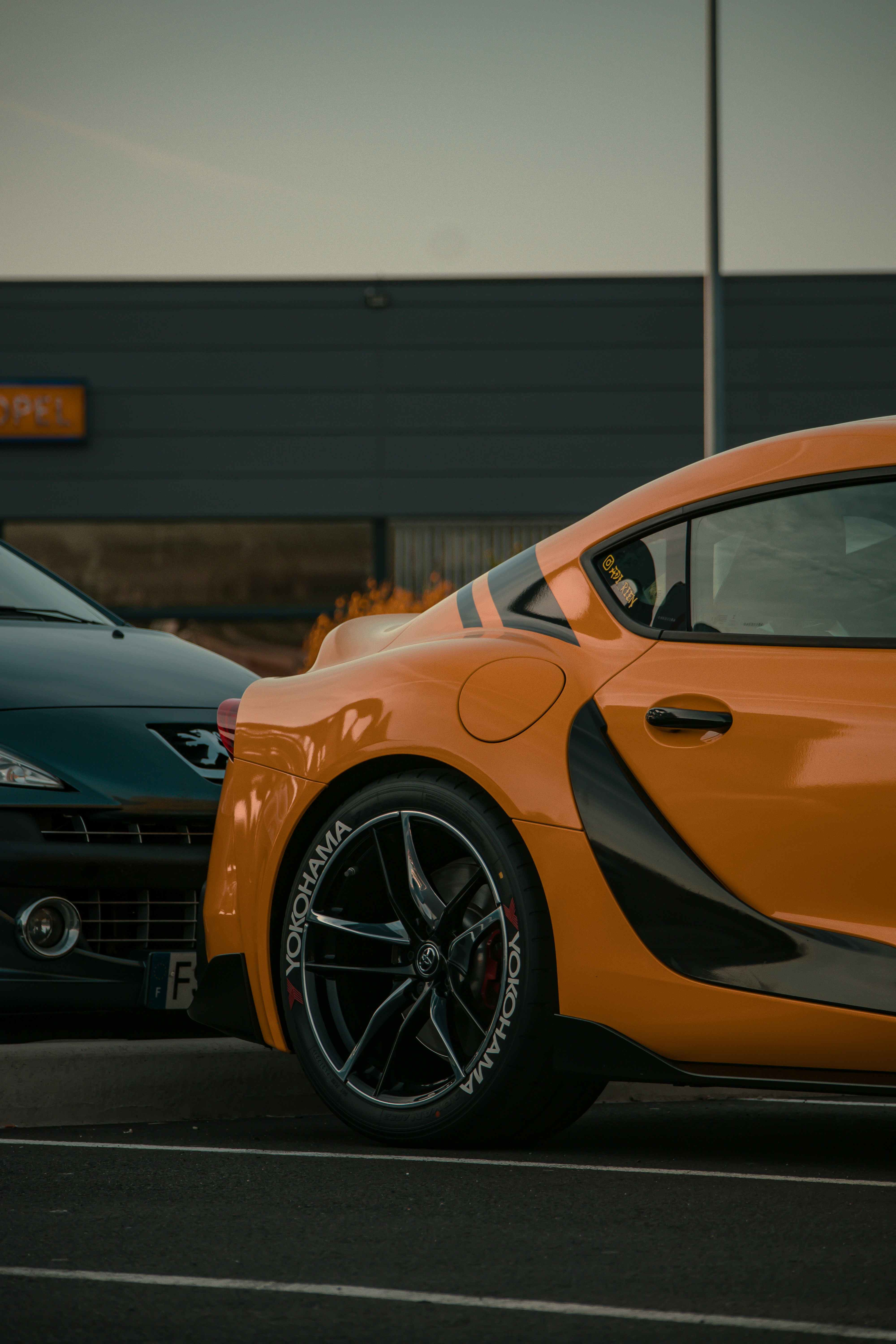 an orange sports car parked in a parking lot