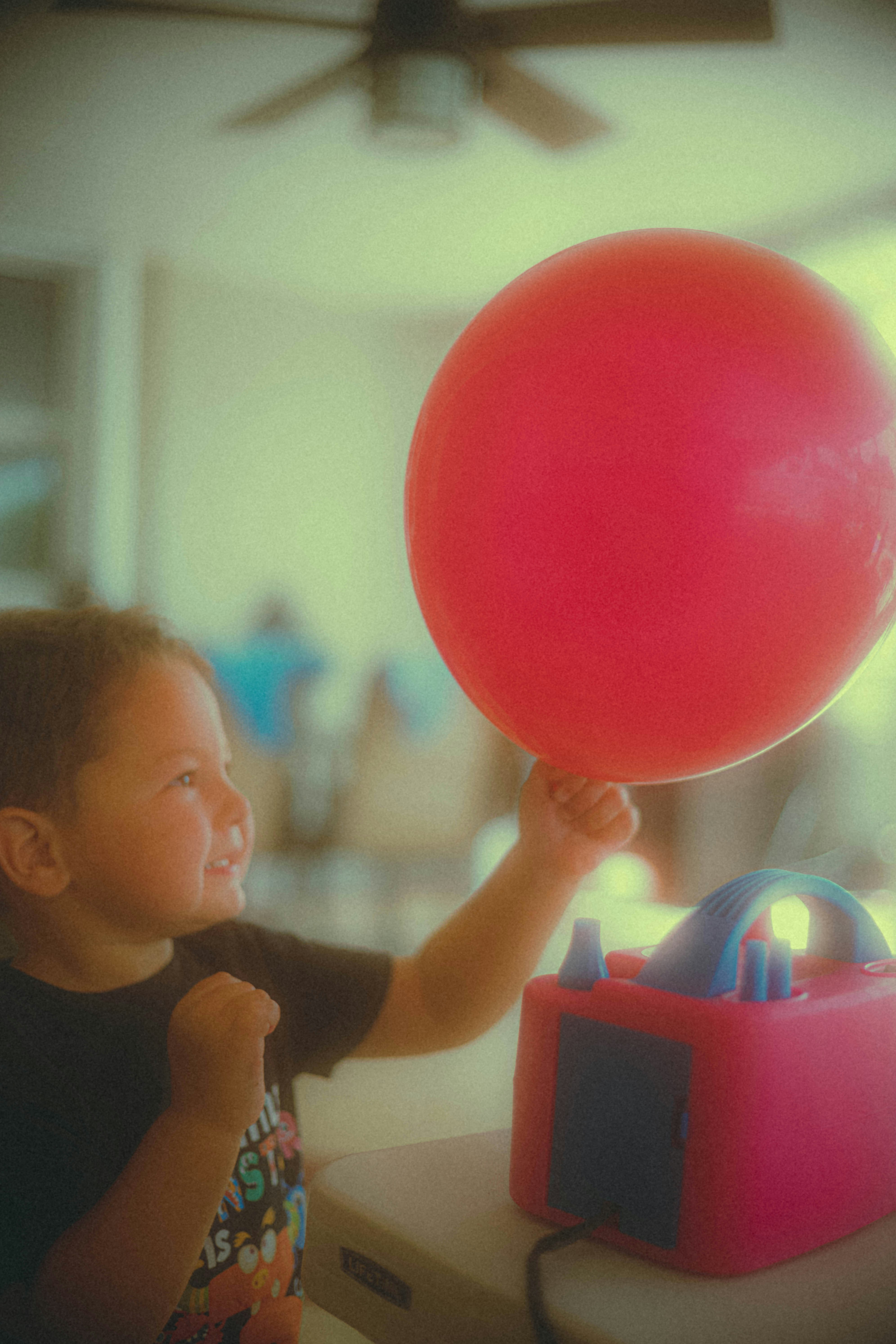 a little boy that is holding a balloon