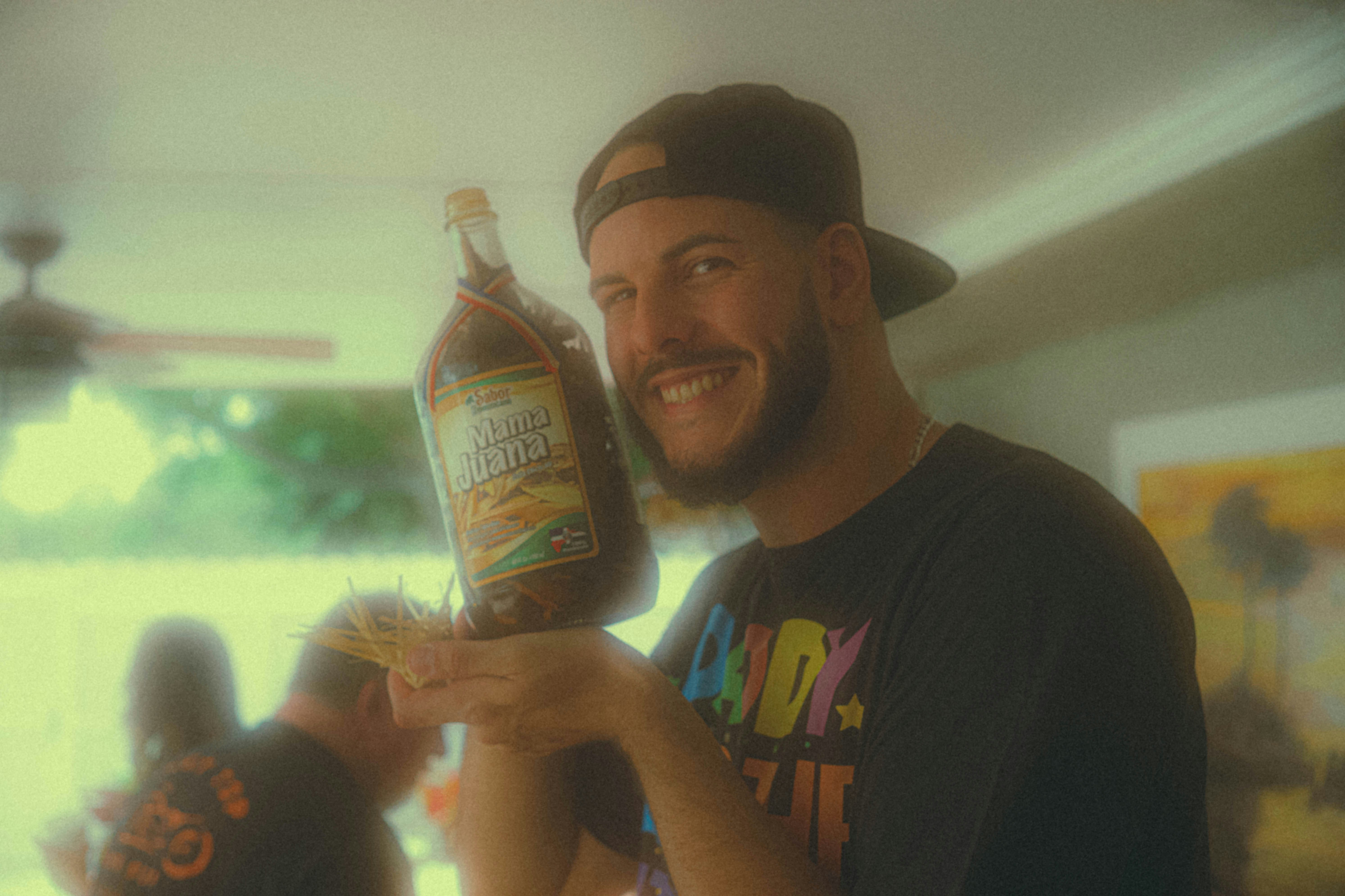 Warm Blur, Bright Grin: A Casual Toast with a Bottled Cheer