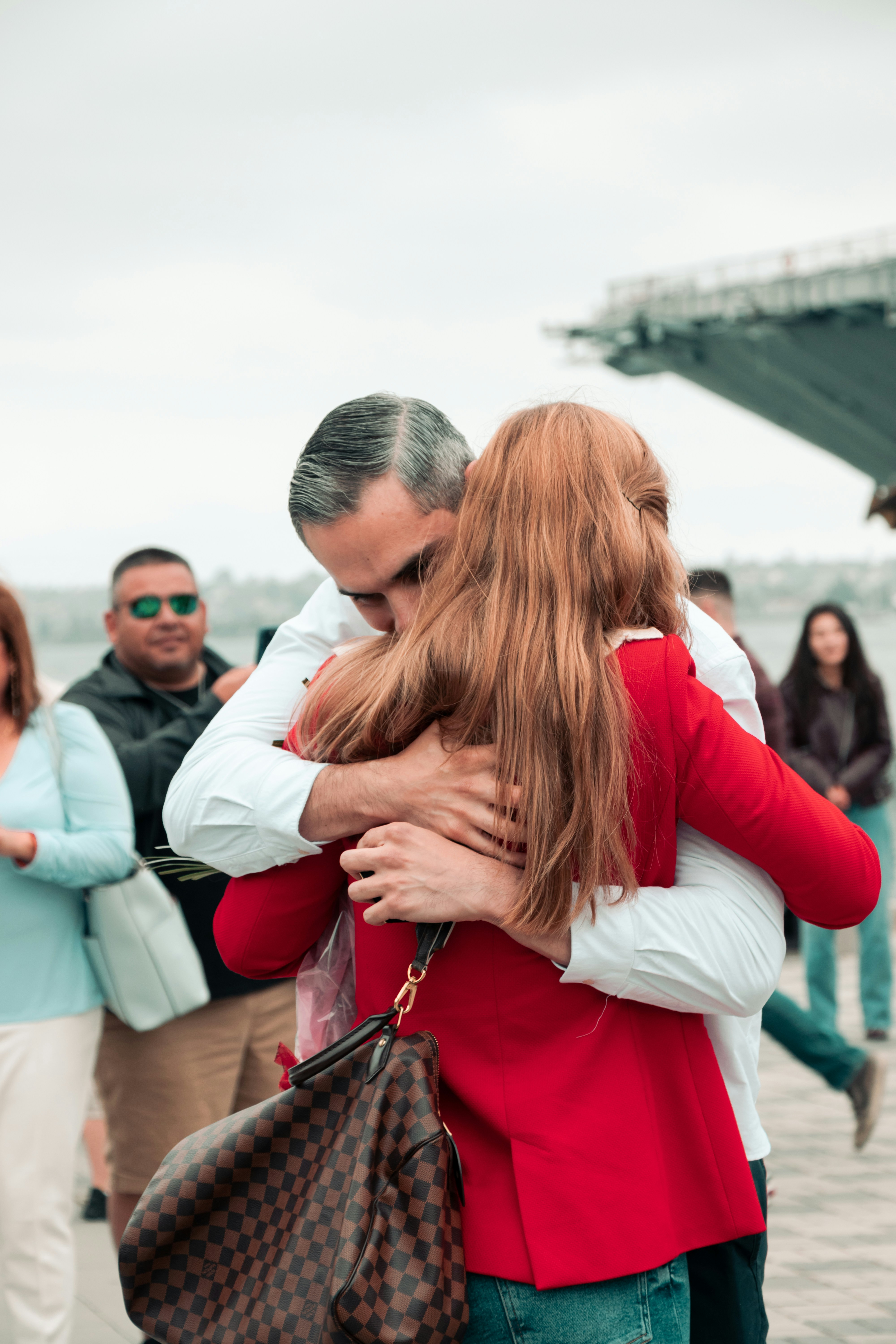A man hugging a woman in front of a crowd of people photo – Free Human ...