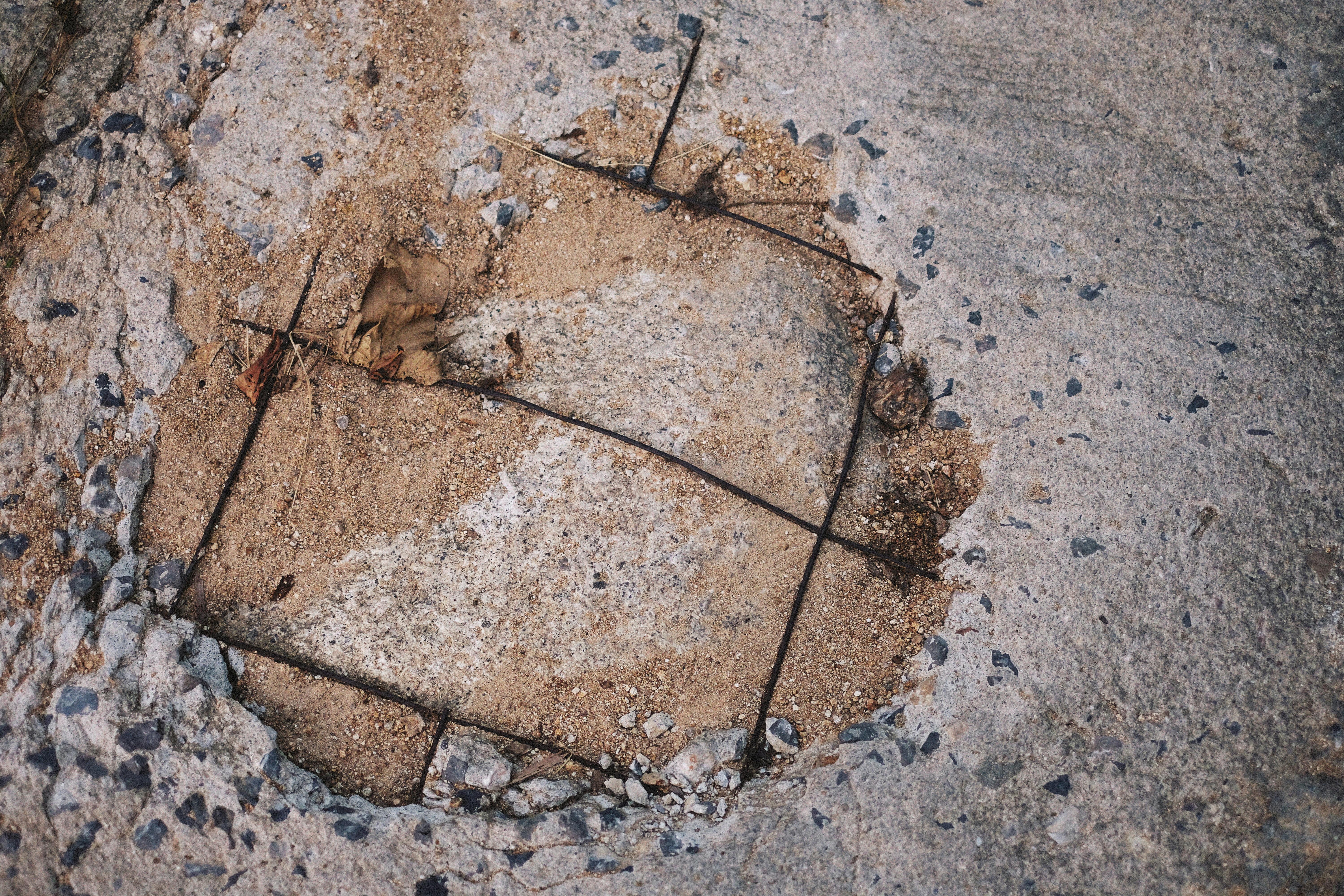 a heart shaped hole in the ground with a wire sticking out of it
