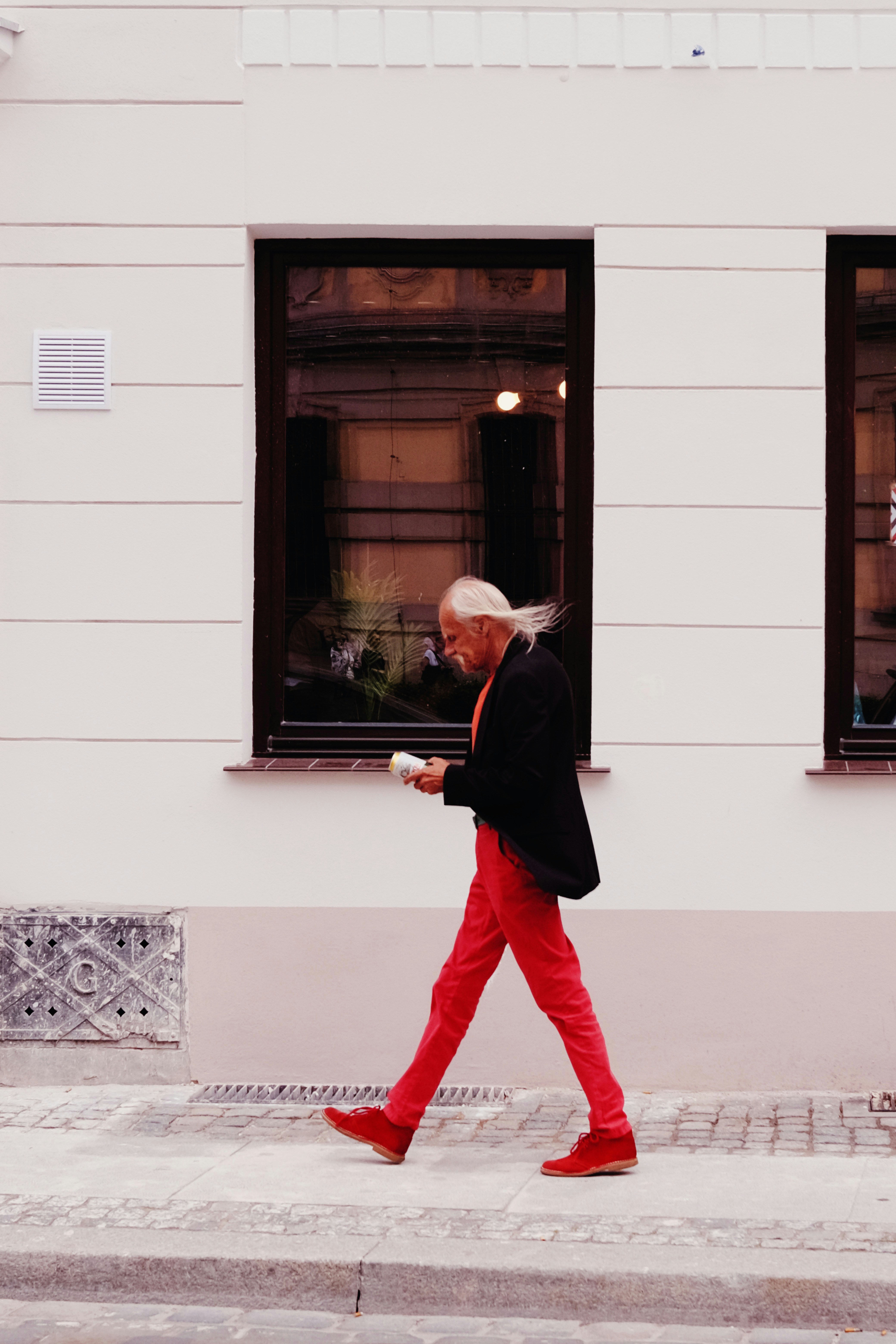 A man in red pants walking down the street photo – Free Wrocław Image ...