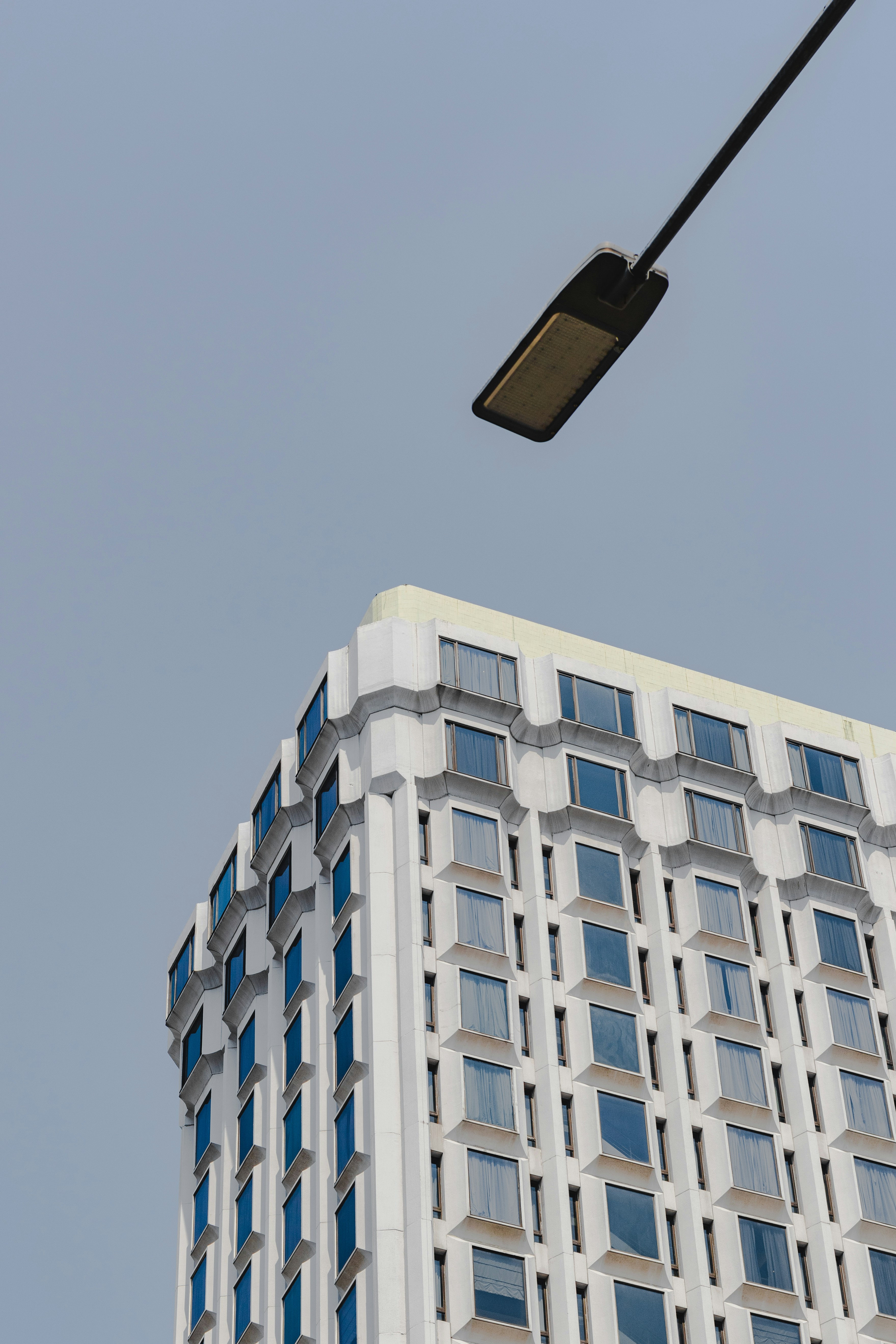 A street light hanging over a tall building photo – Free Singapore ...