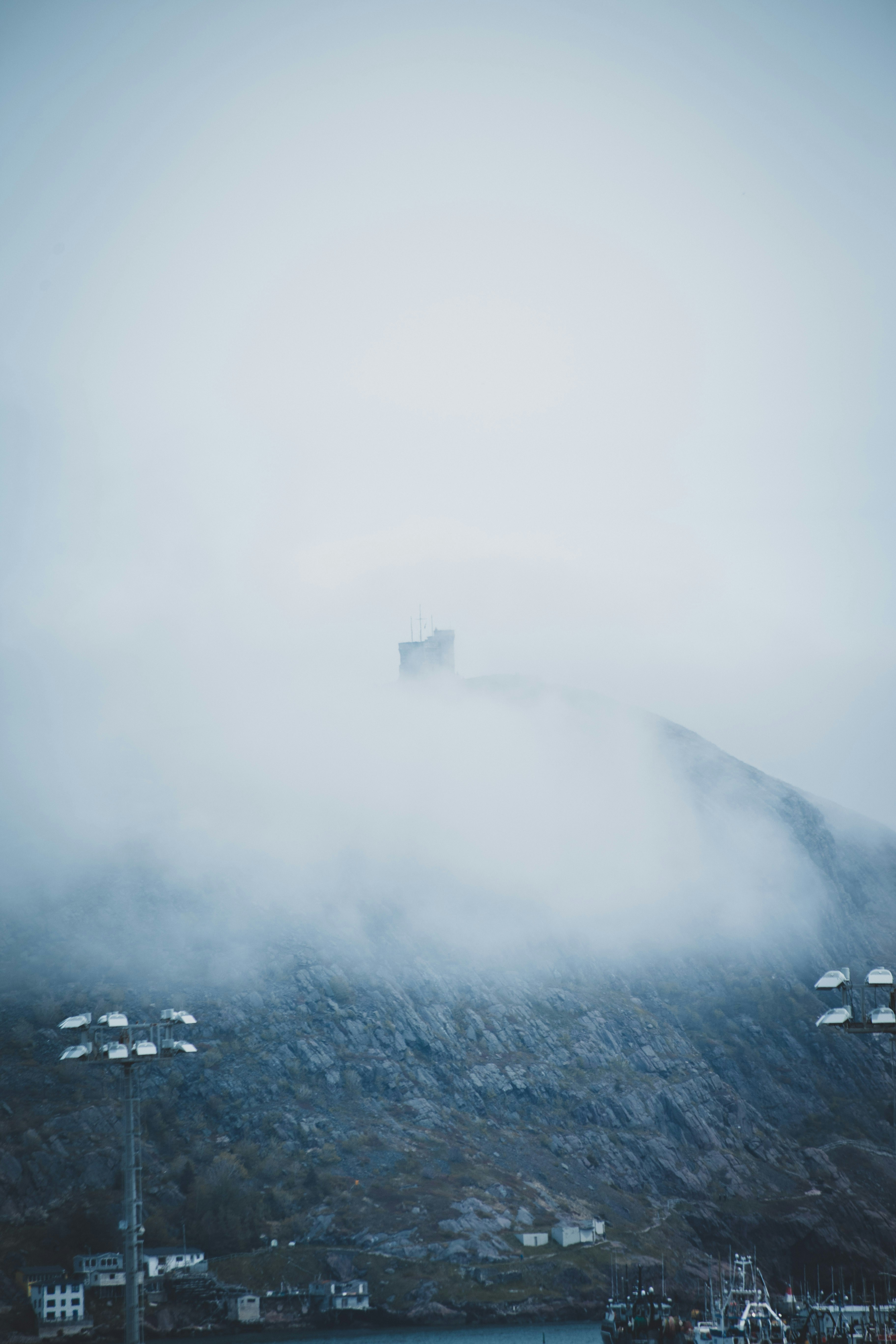 a foggy mountain with a castle in the distance