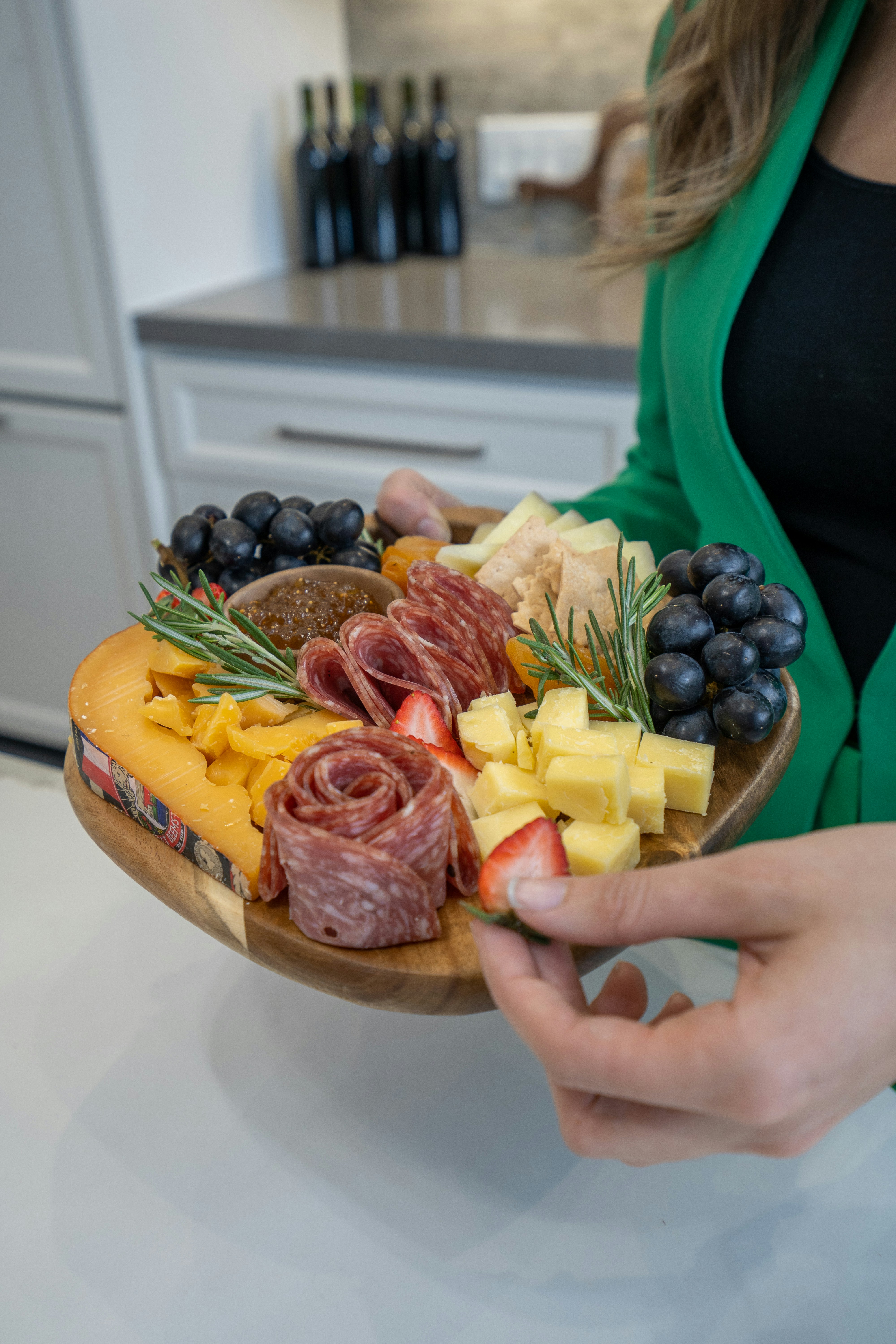 Hand-Held Charcuterie Board: Cheese, Salami, and Grapes in a Modern Kitchen