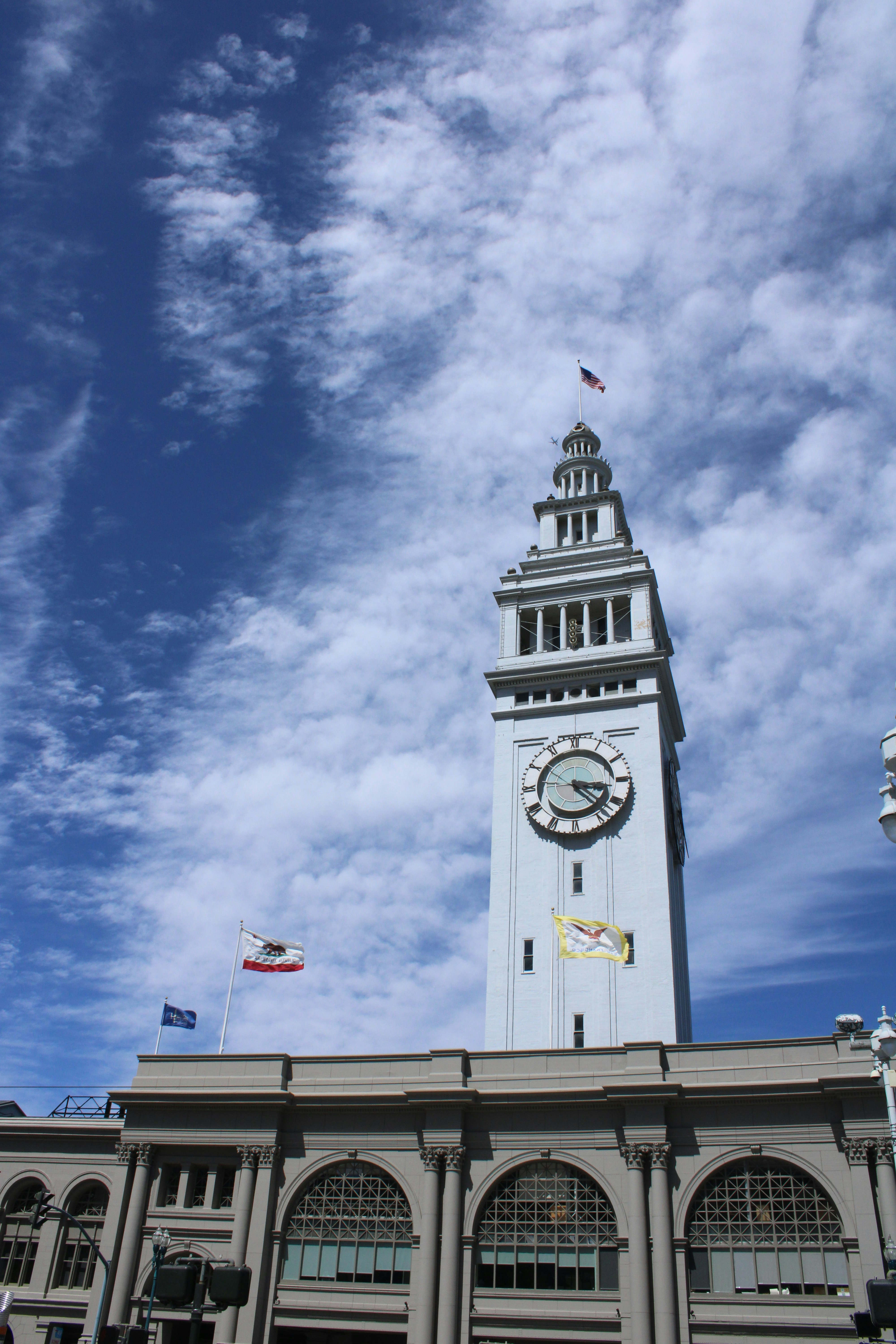 Ascendant Clock Tower Over an Arched Facade Beneath a Crisp Blue Sky