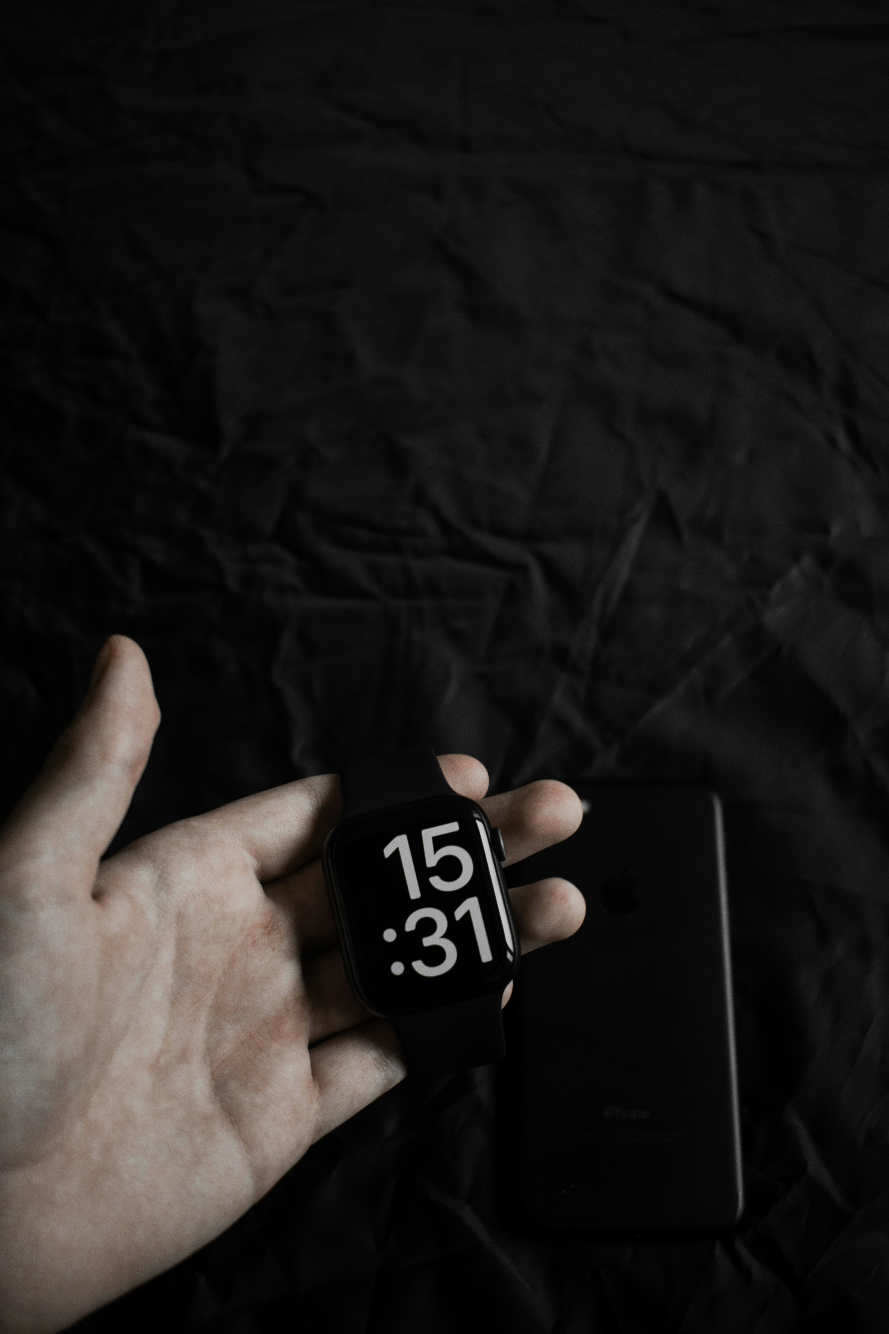 Noir Wristtime: A Hand, a Smartwatch, and a Slumbering Phone on Velvet Black