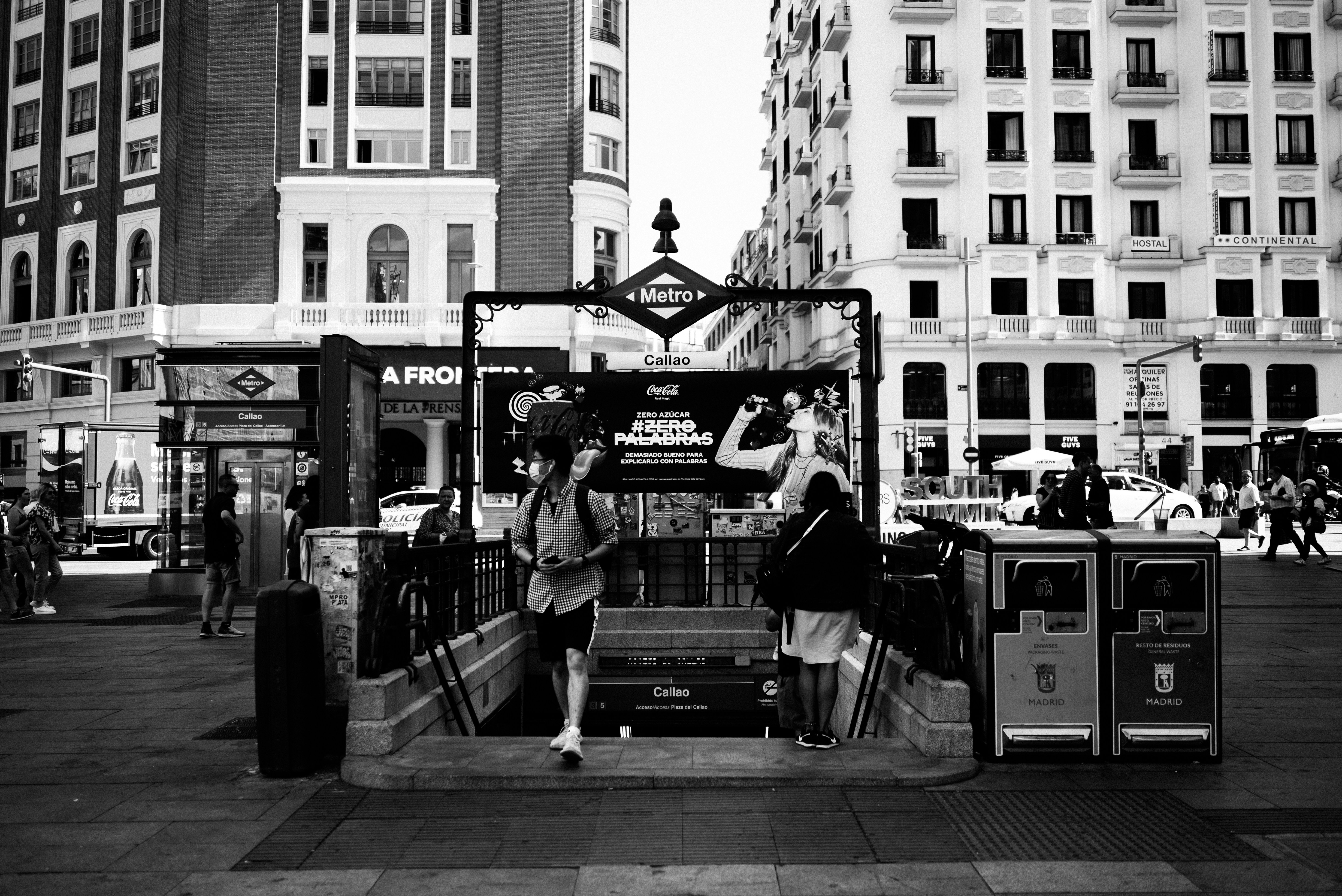Metro Threshold: Two Passersby Pause at the City Entrance