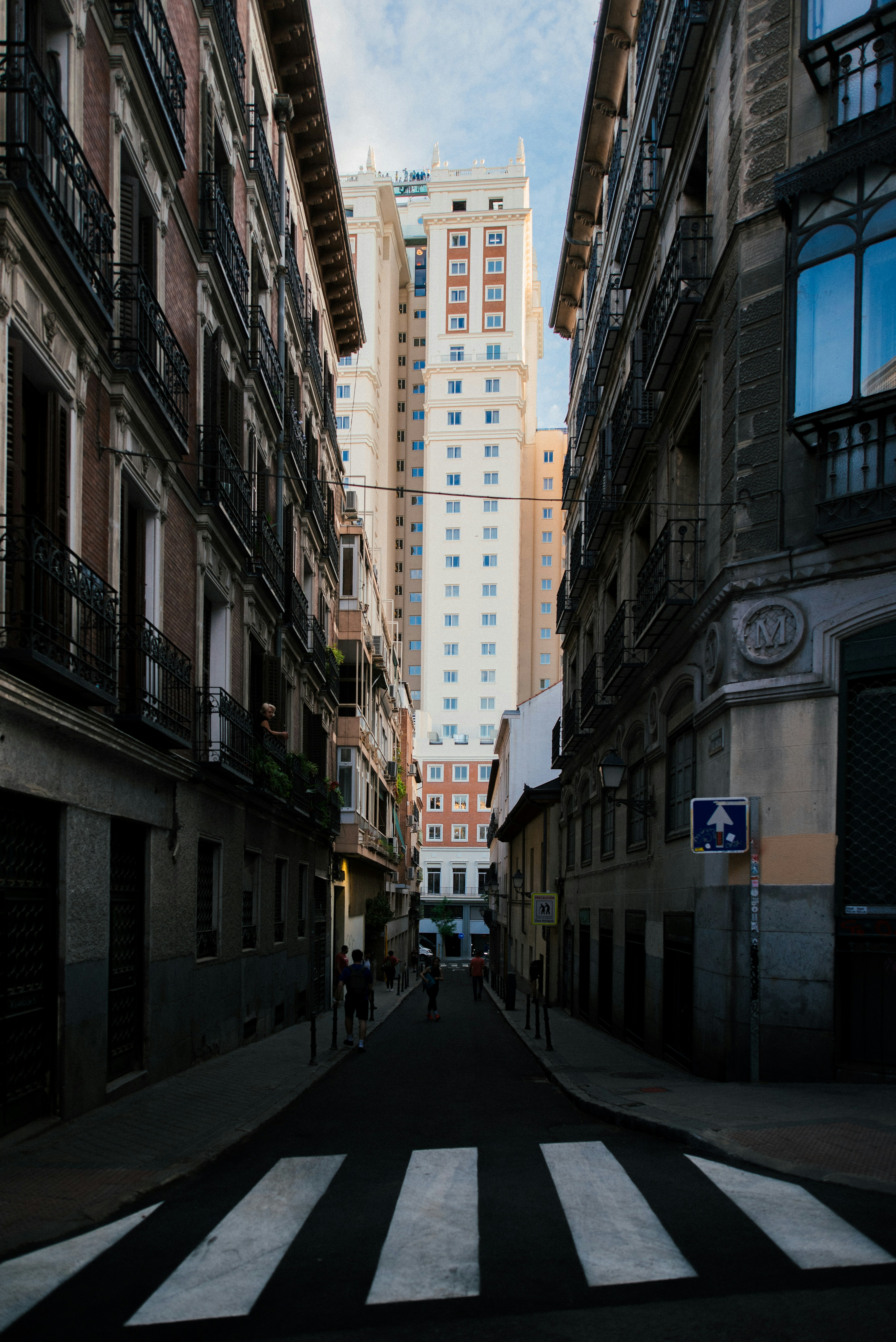 Convergence Under Canyon Facades: A Narrow Street Reaches a Towering Spire