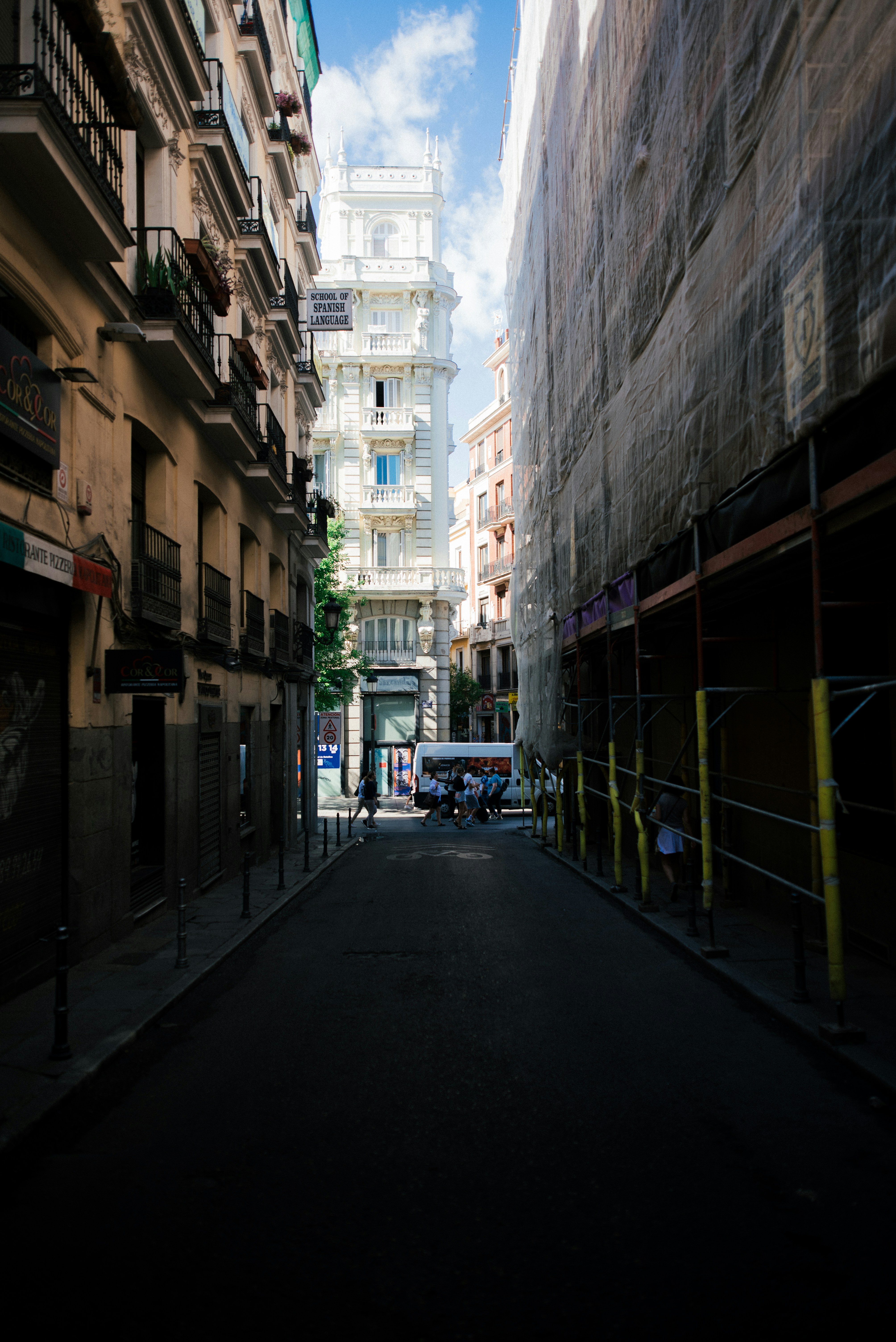 End of the Street: A Sunlit White Facade Anchoring a Narrow City Lane