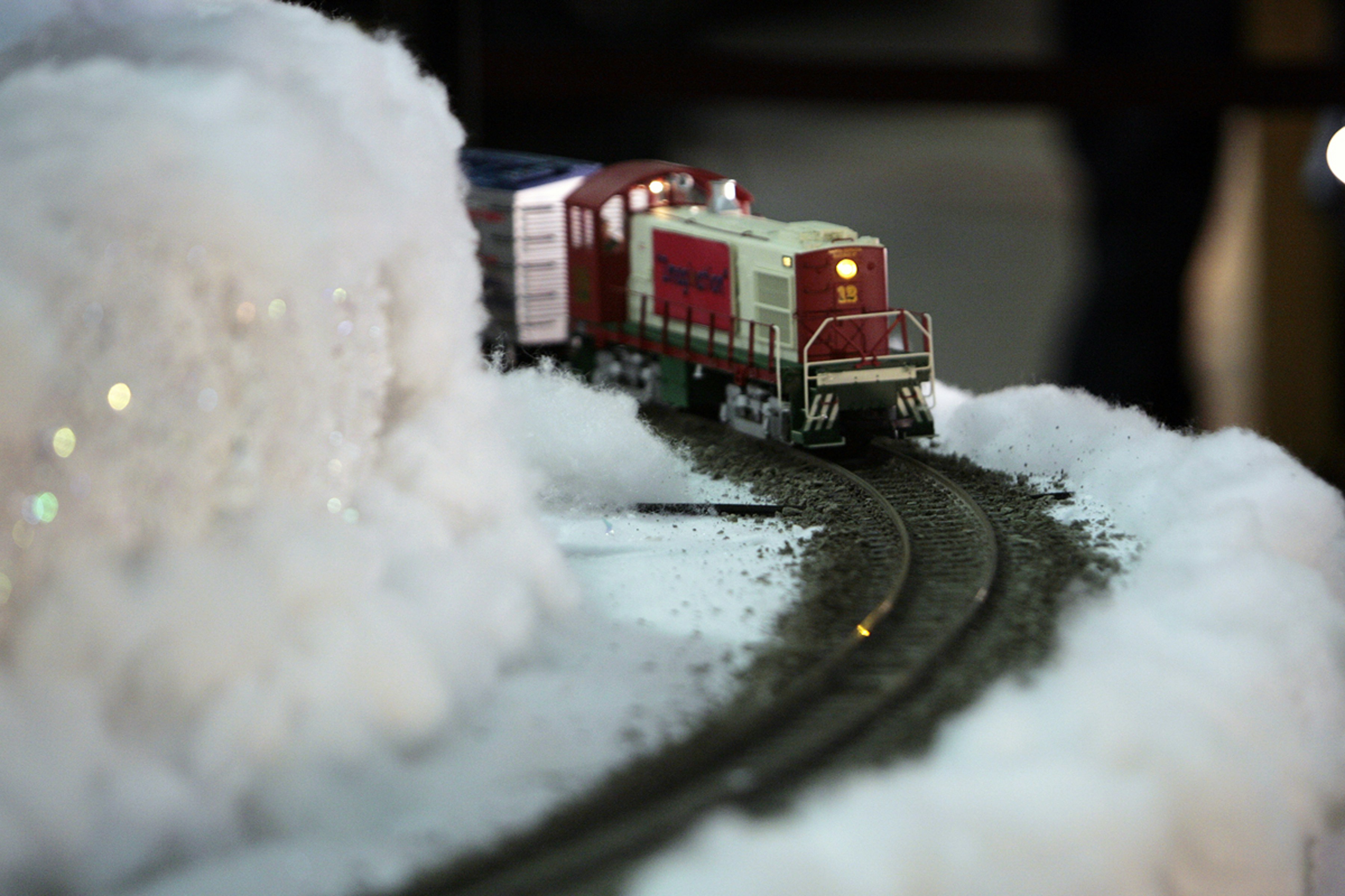 Snow-Dusted Rails: A Tiny Red Locomotive Navigates a Curved Winter Track