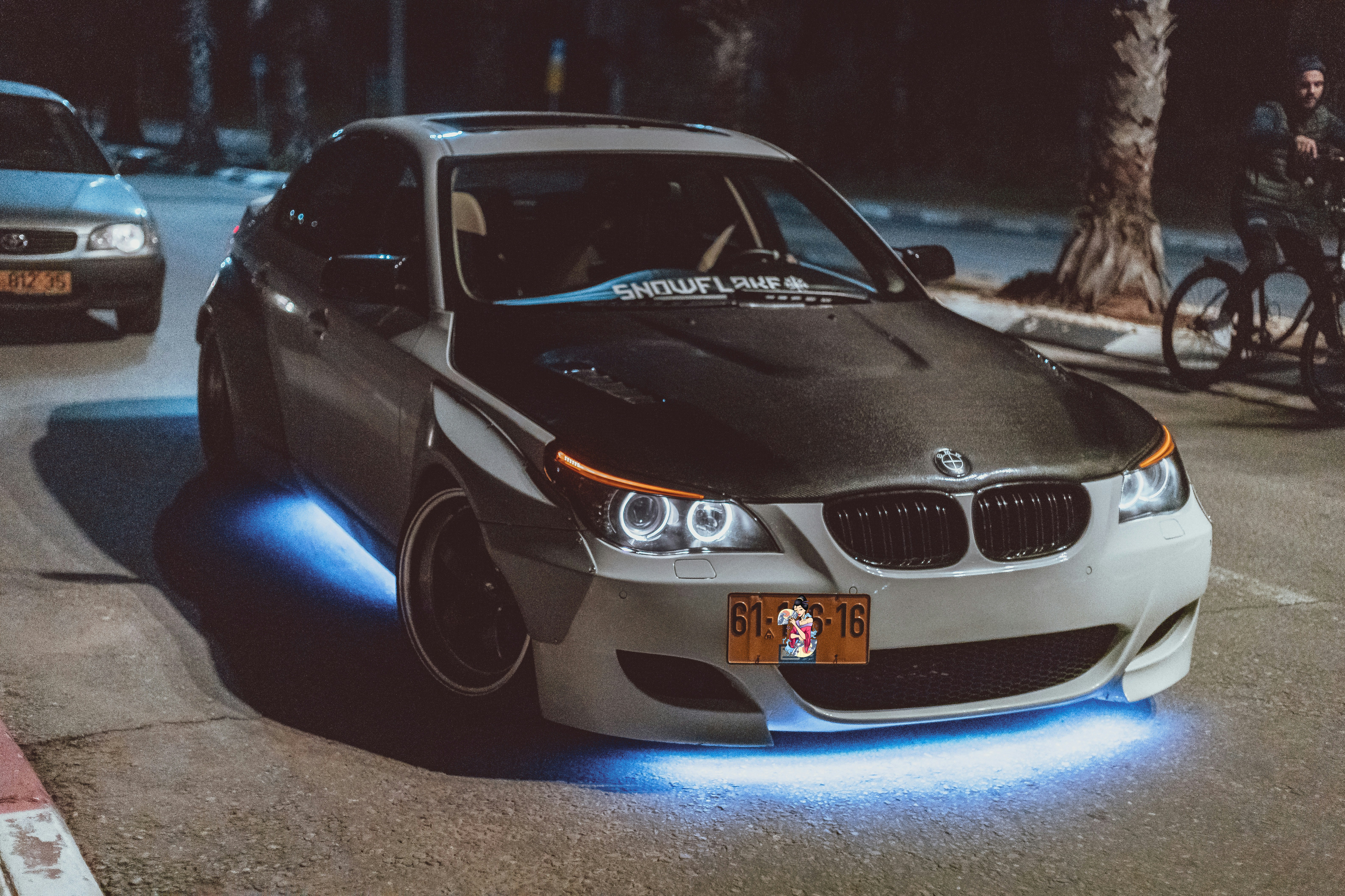 Midnight BMW with cobalt underglow lighting a quiet urban street
