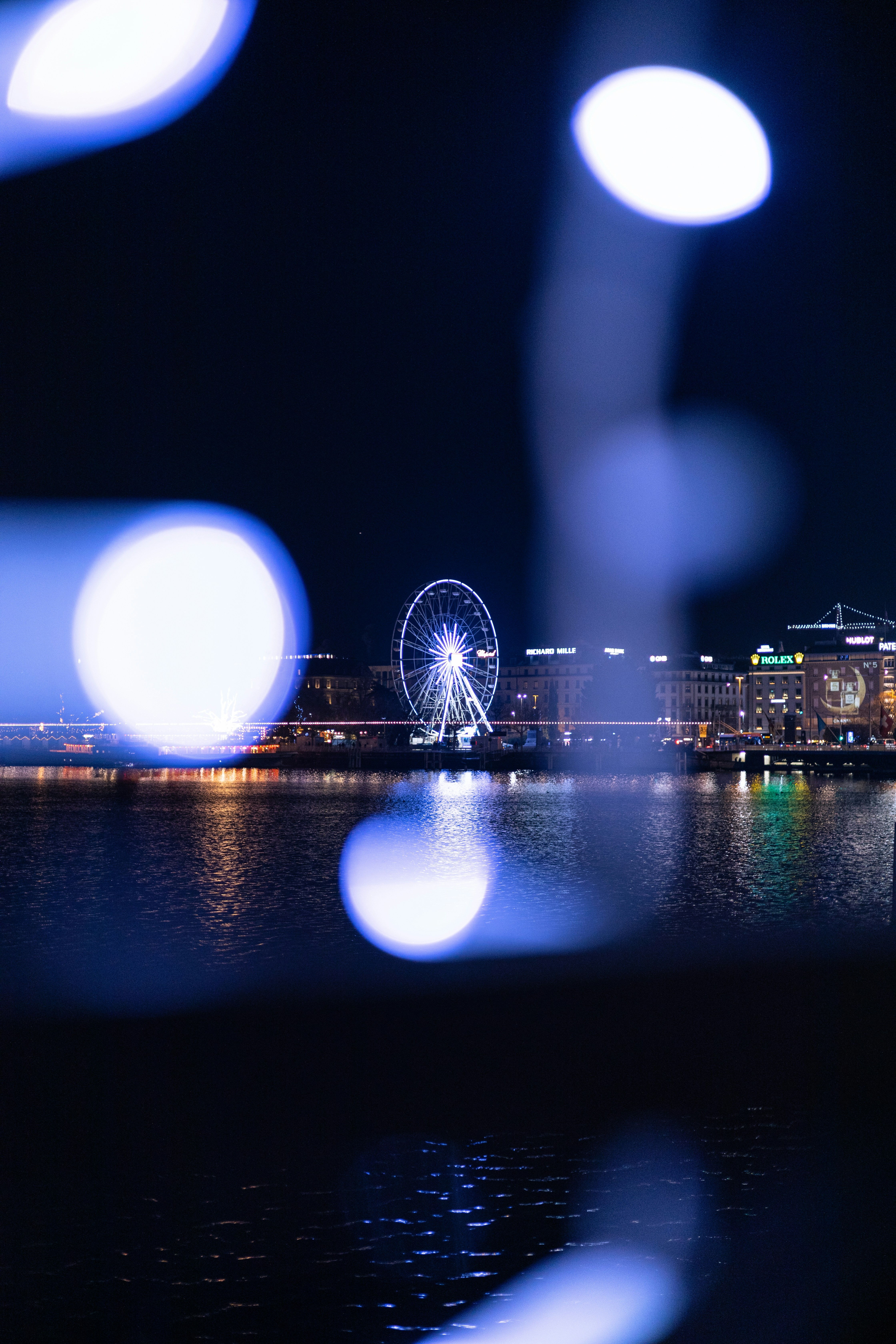 Un cuerpo de agua con una noria en el fondo foto – Imagen de Azul ...