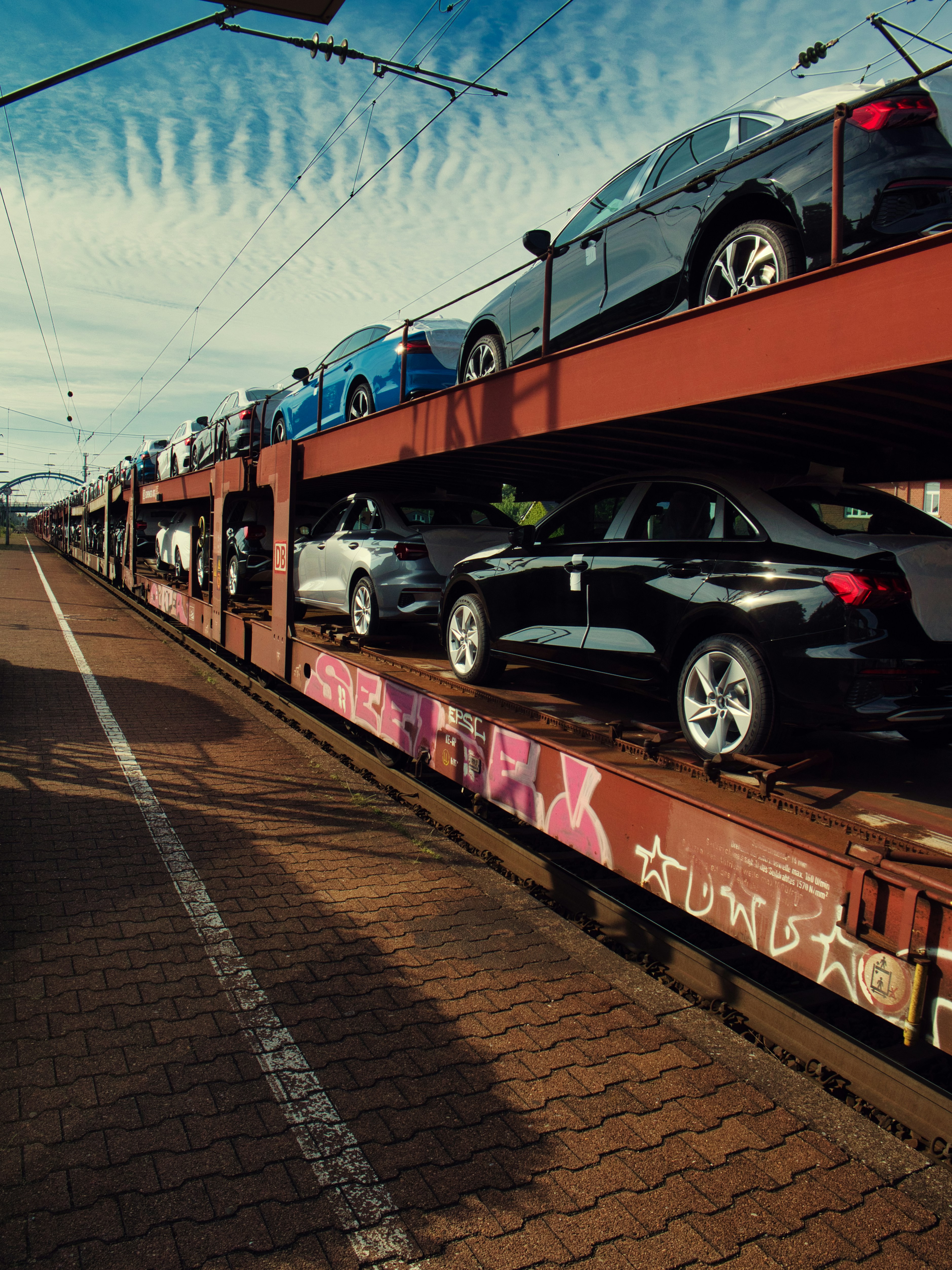 Chrome on Rails: A Daylight Parade of Sedans on a Car Carrier