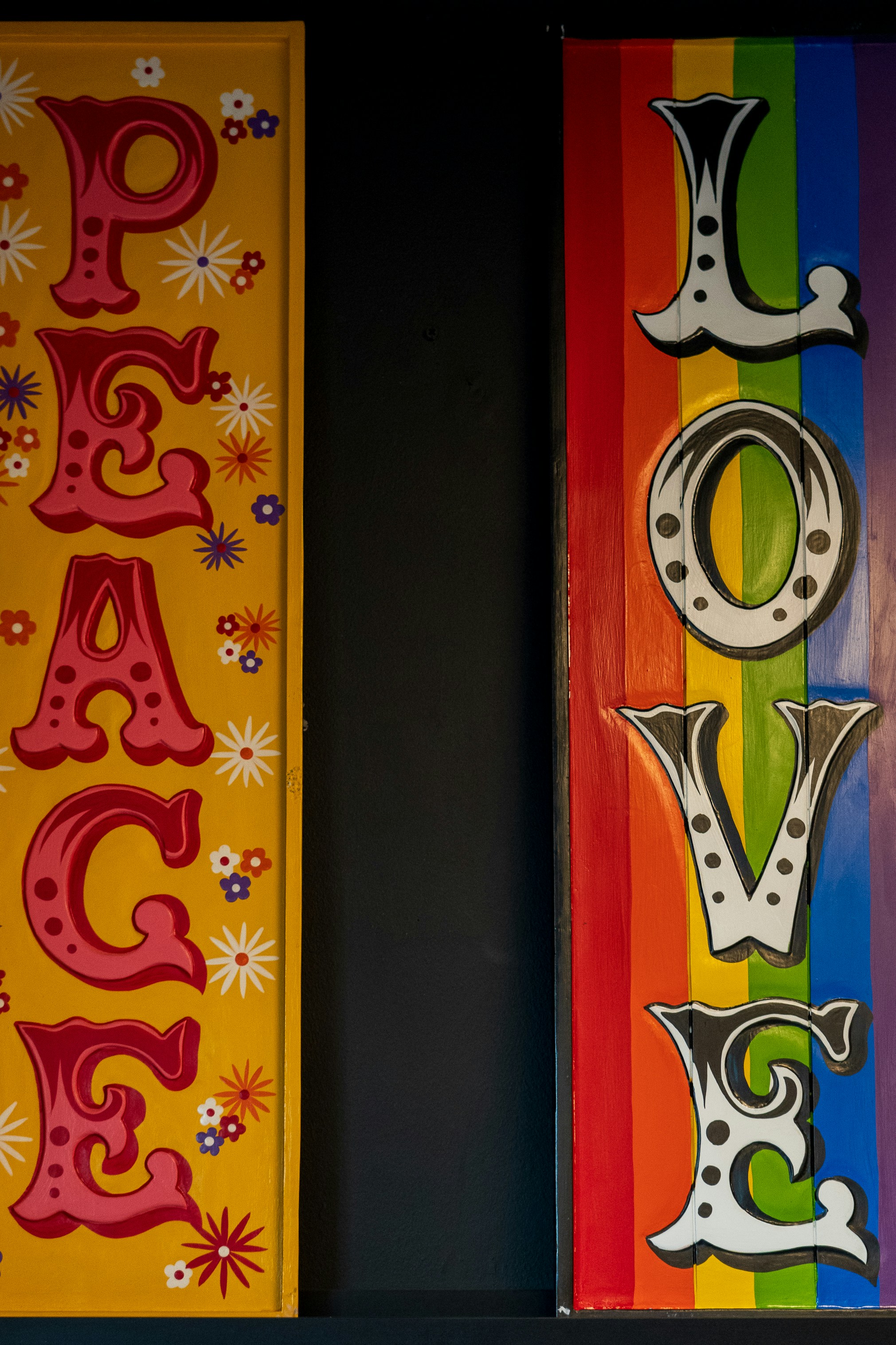 Colorful wall art featuring the words 'PEACE' and 'LOVE' in bold, playful typography against a vibrant background.