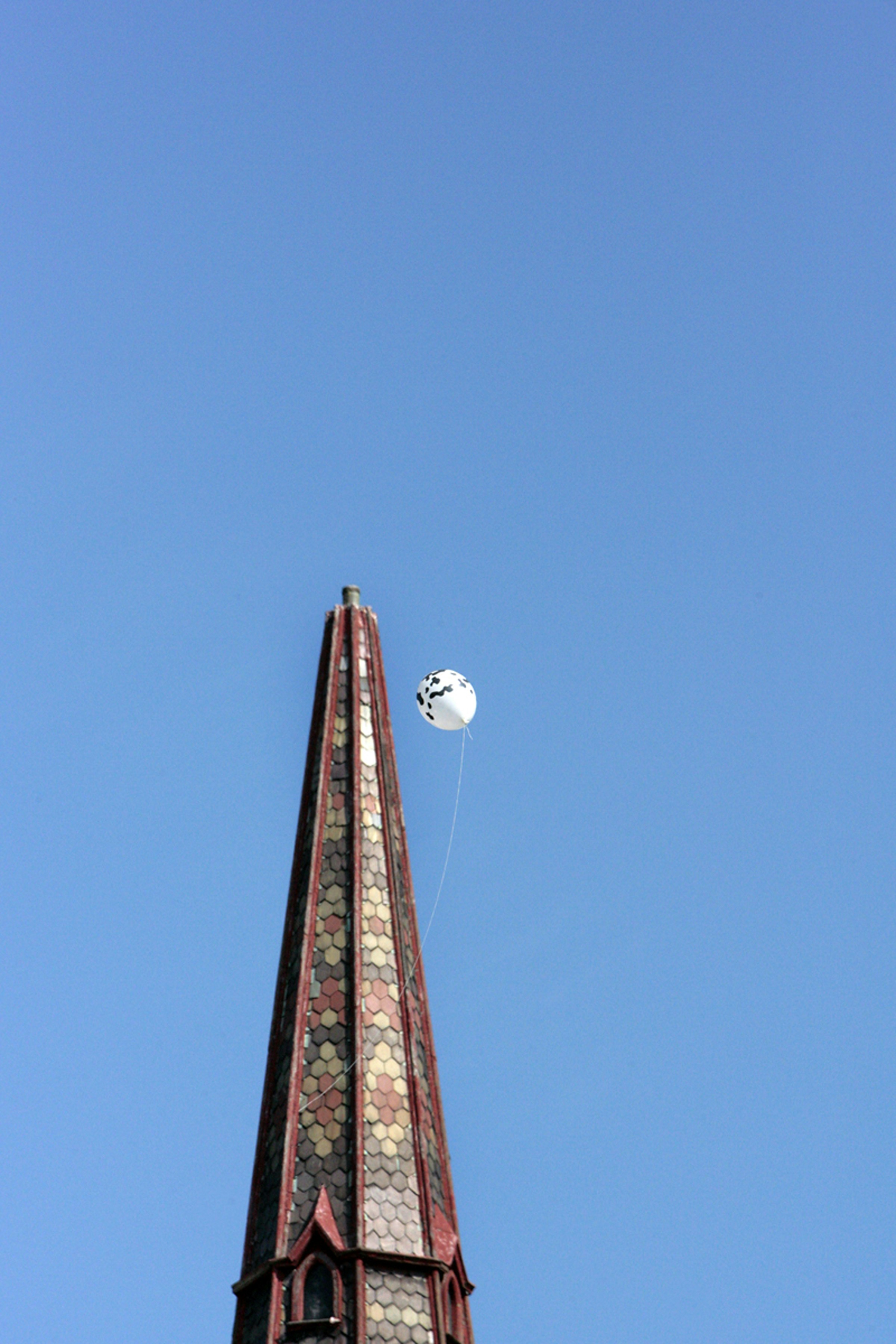 Balloon Over a Tiled Spire: A Quiet Moment in Blue