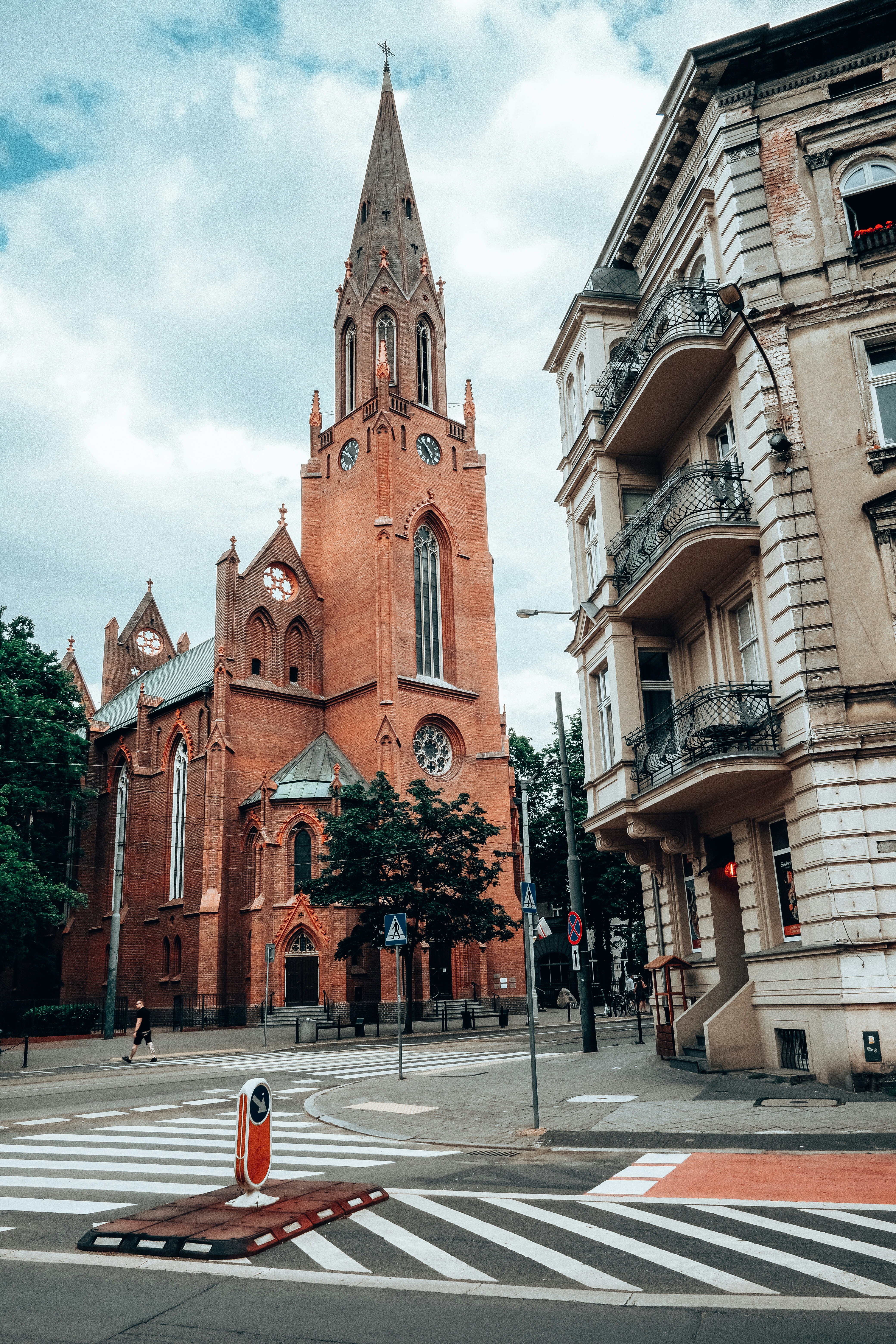 Poznan, Poland | a large building towers over a crosswalk