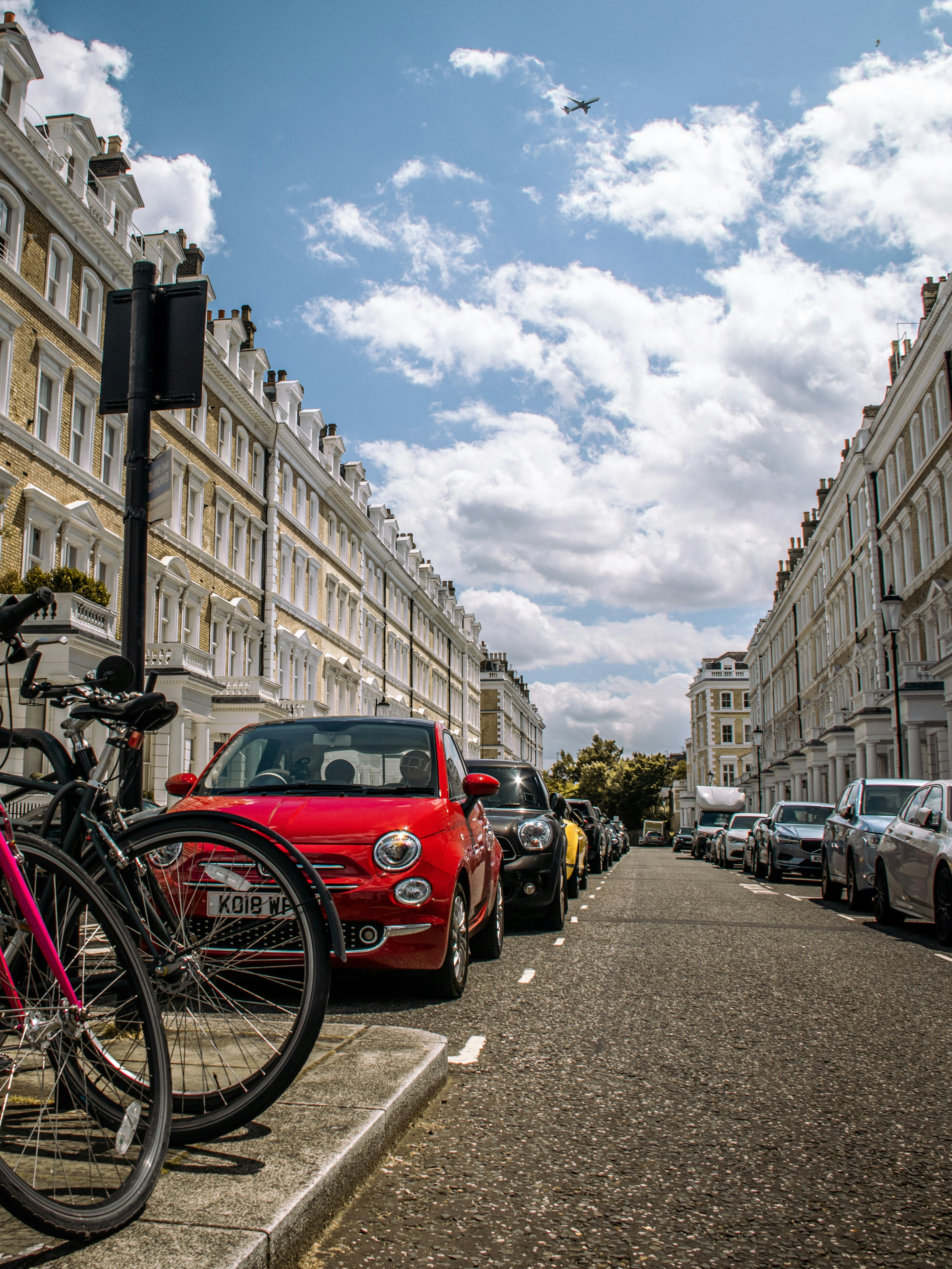 Red Fiat 500 Anchors a London Street Portrait of Bicycles and Sky
