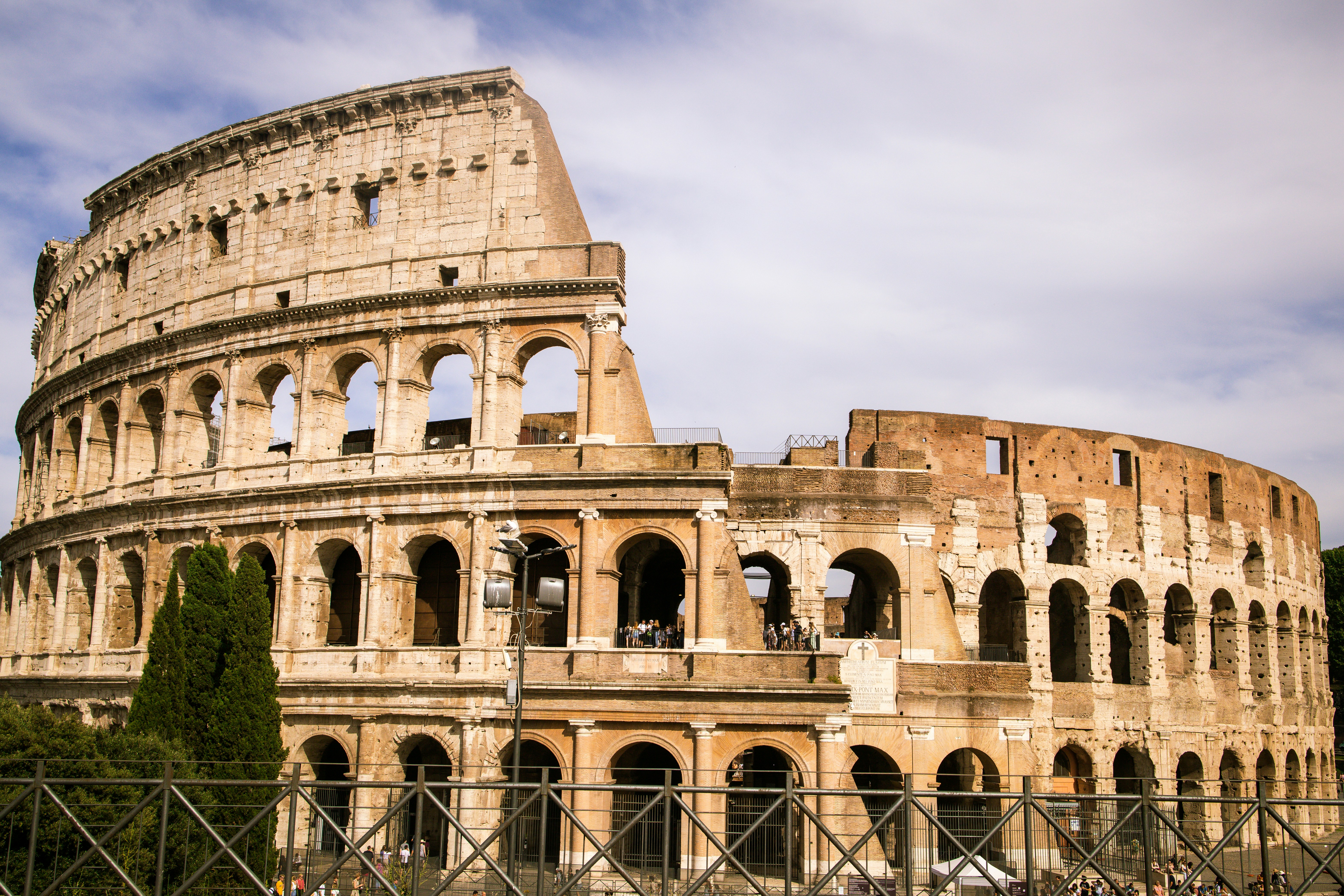 A large stone building with Colosseum in the background photo – Free ...