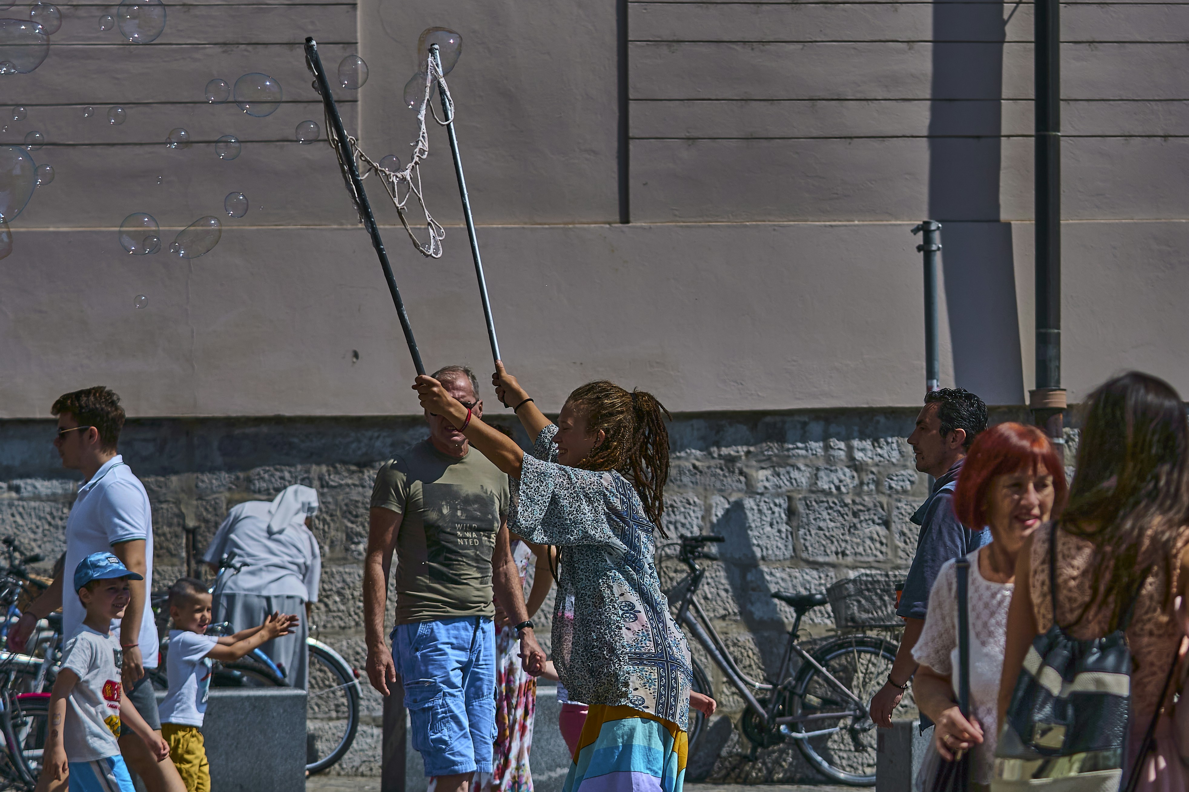 a group of people standing around a person shooting a bow and arrow