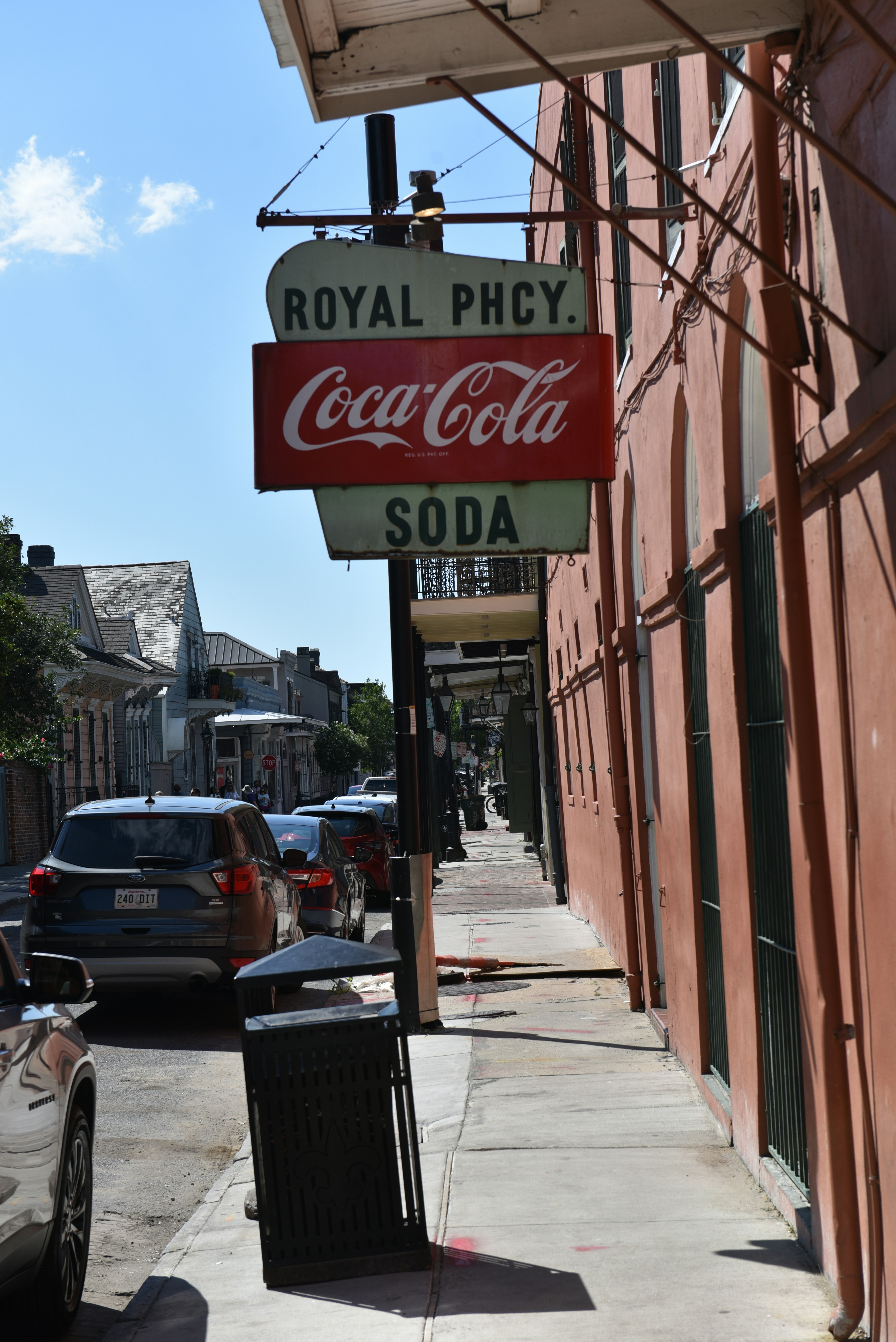 Sunlit Coca-Cola Sign Over a Quiet Red-Brick Street in Morning Light
