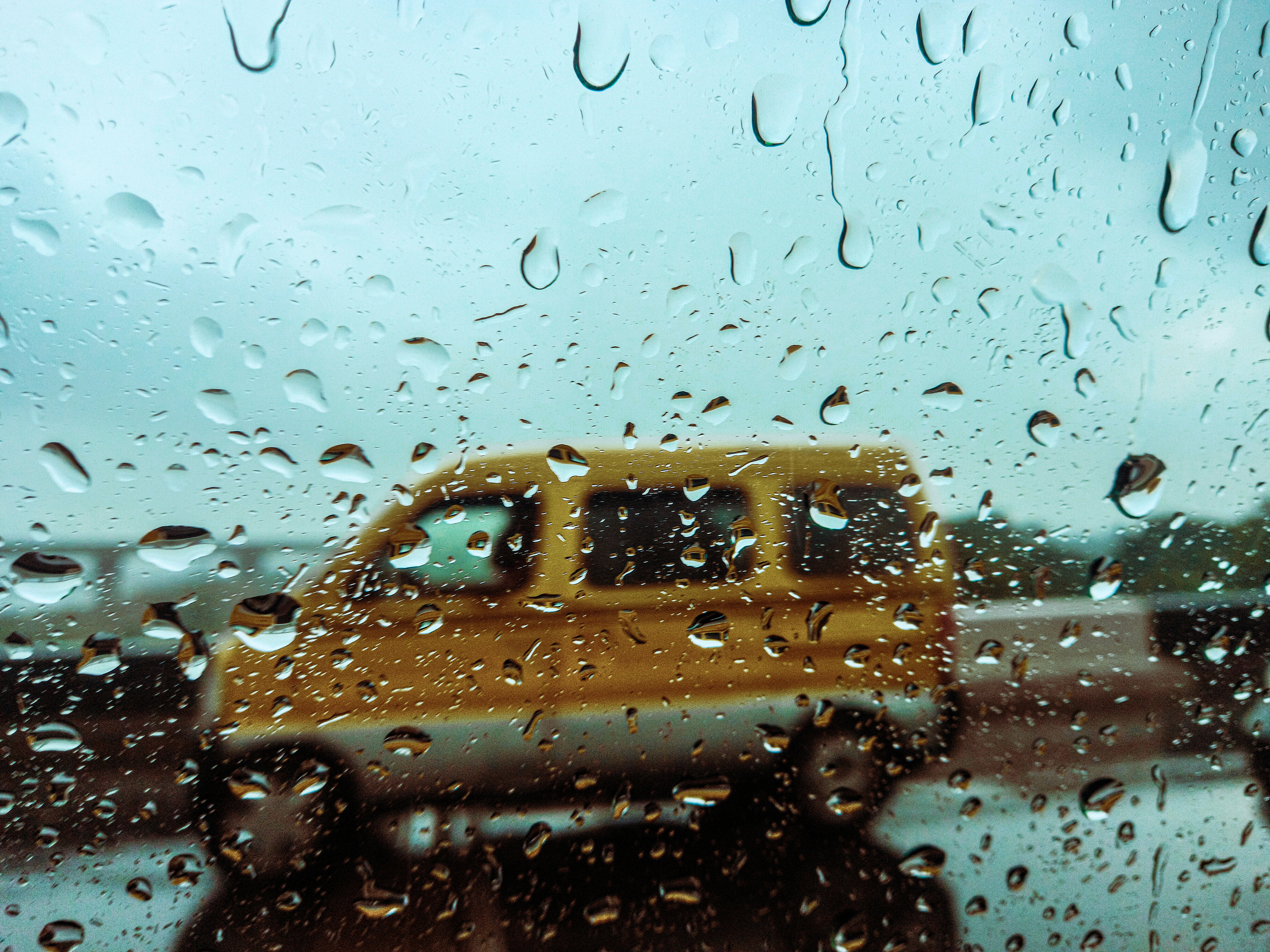 Rain-splashed Yellow School Bus on a Wet Highway