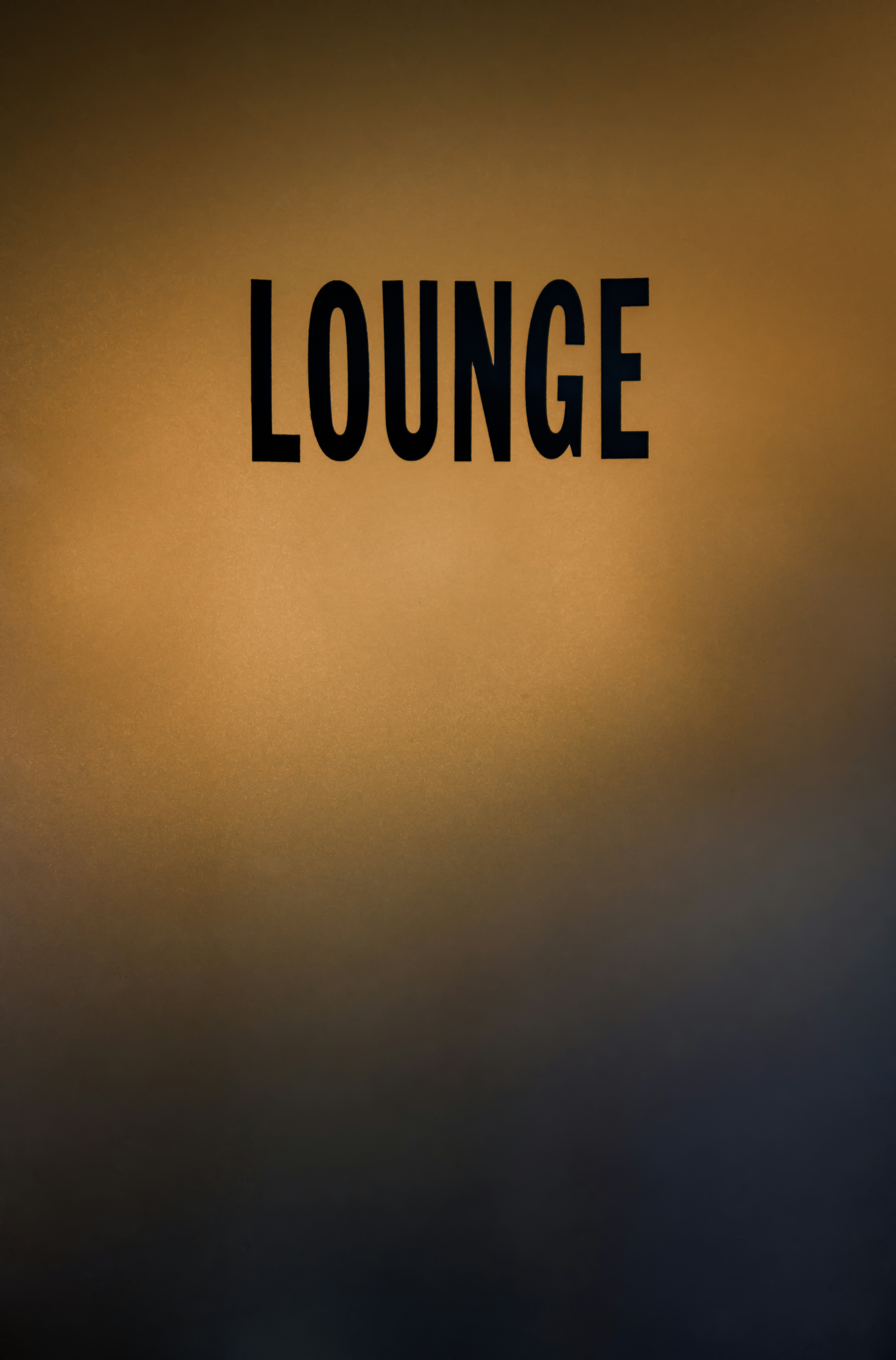 Amber-Backlit LOUNGE Sign: A Quiet Wall Portrait