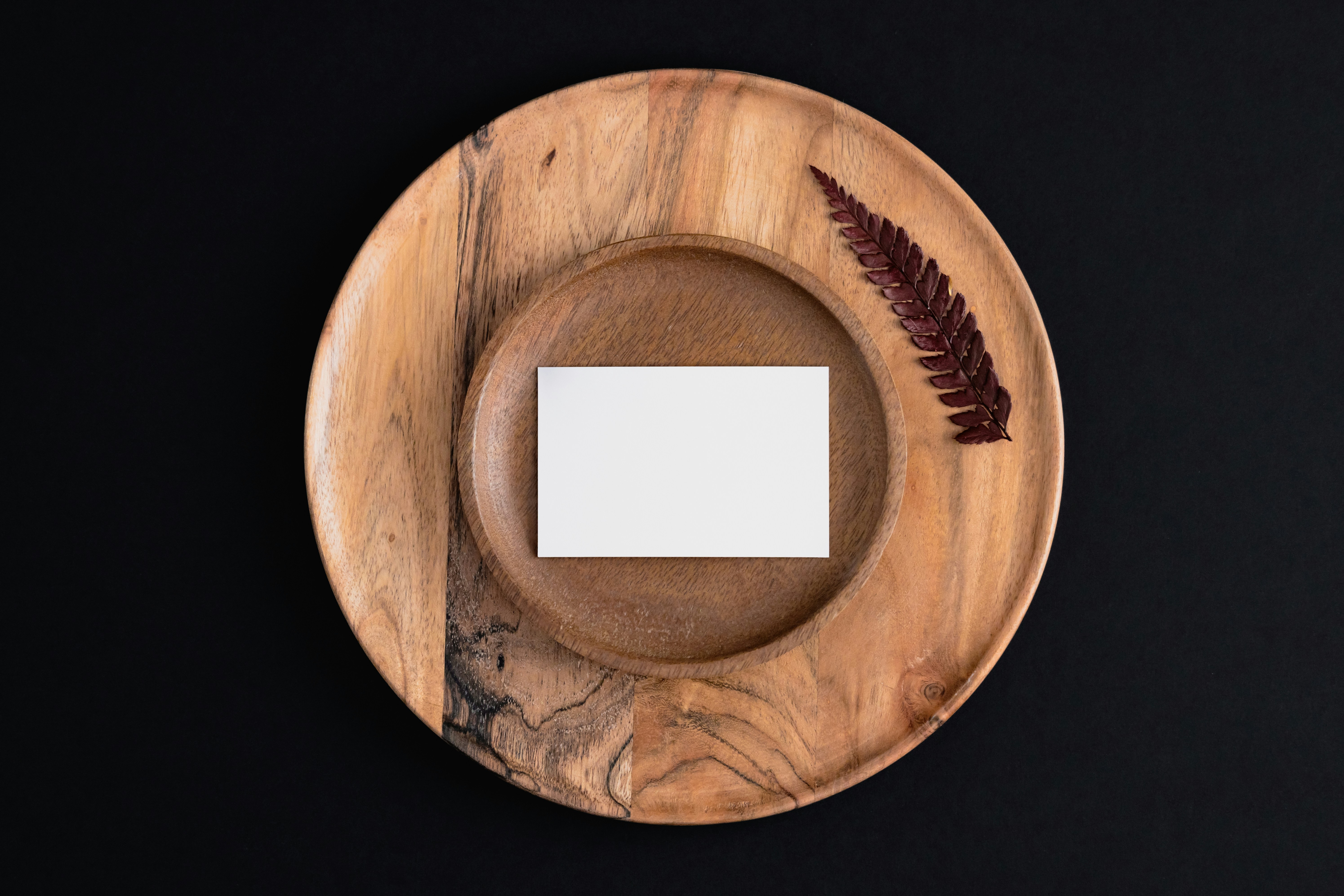 Centerpiece of Simplicity: White Card on a Wooden Plate with a Red Leaf