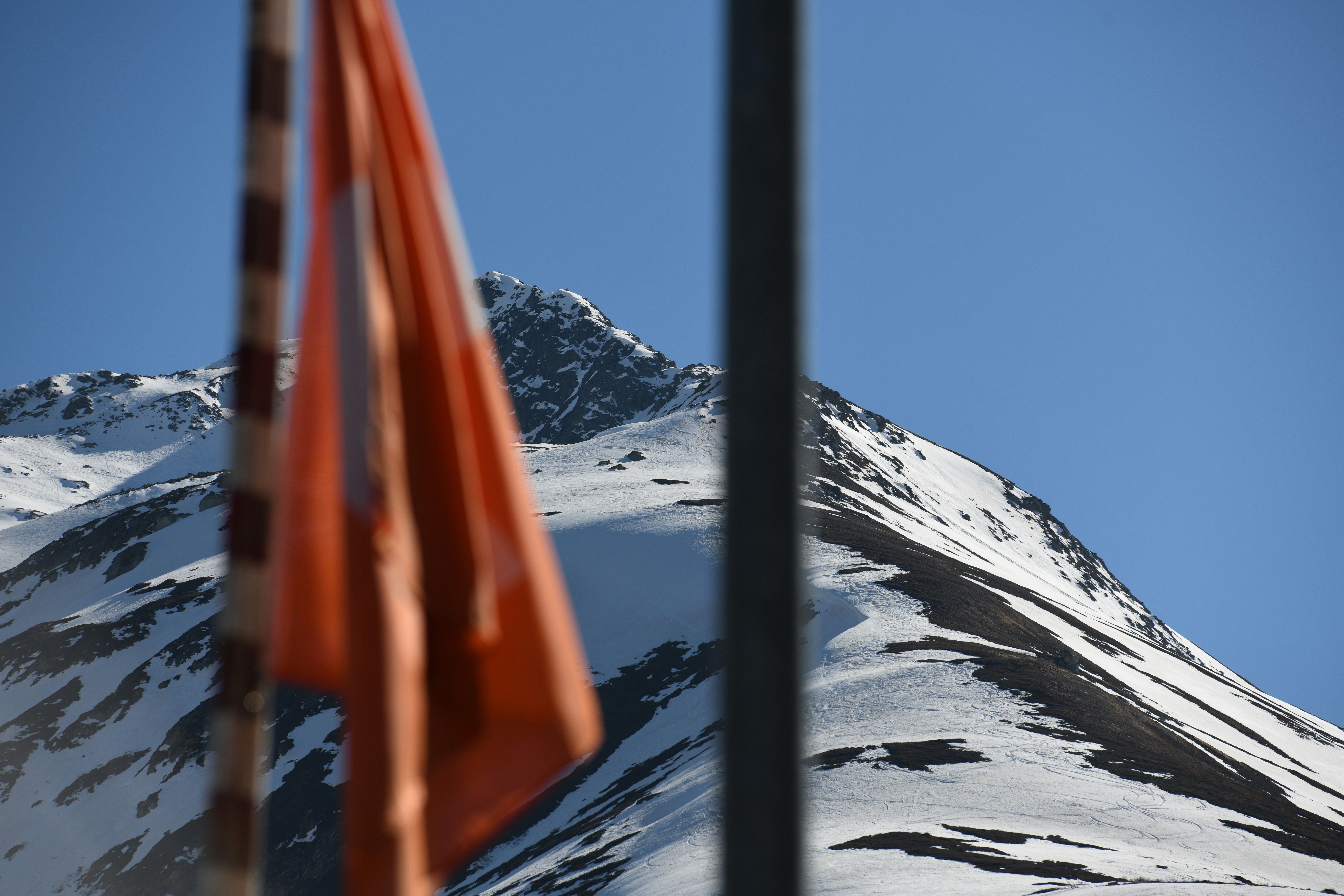 a red metal gate on a snowy mountain