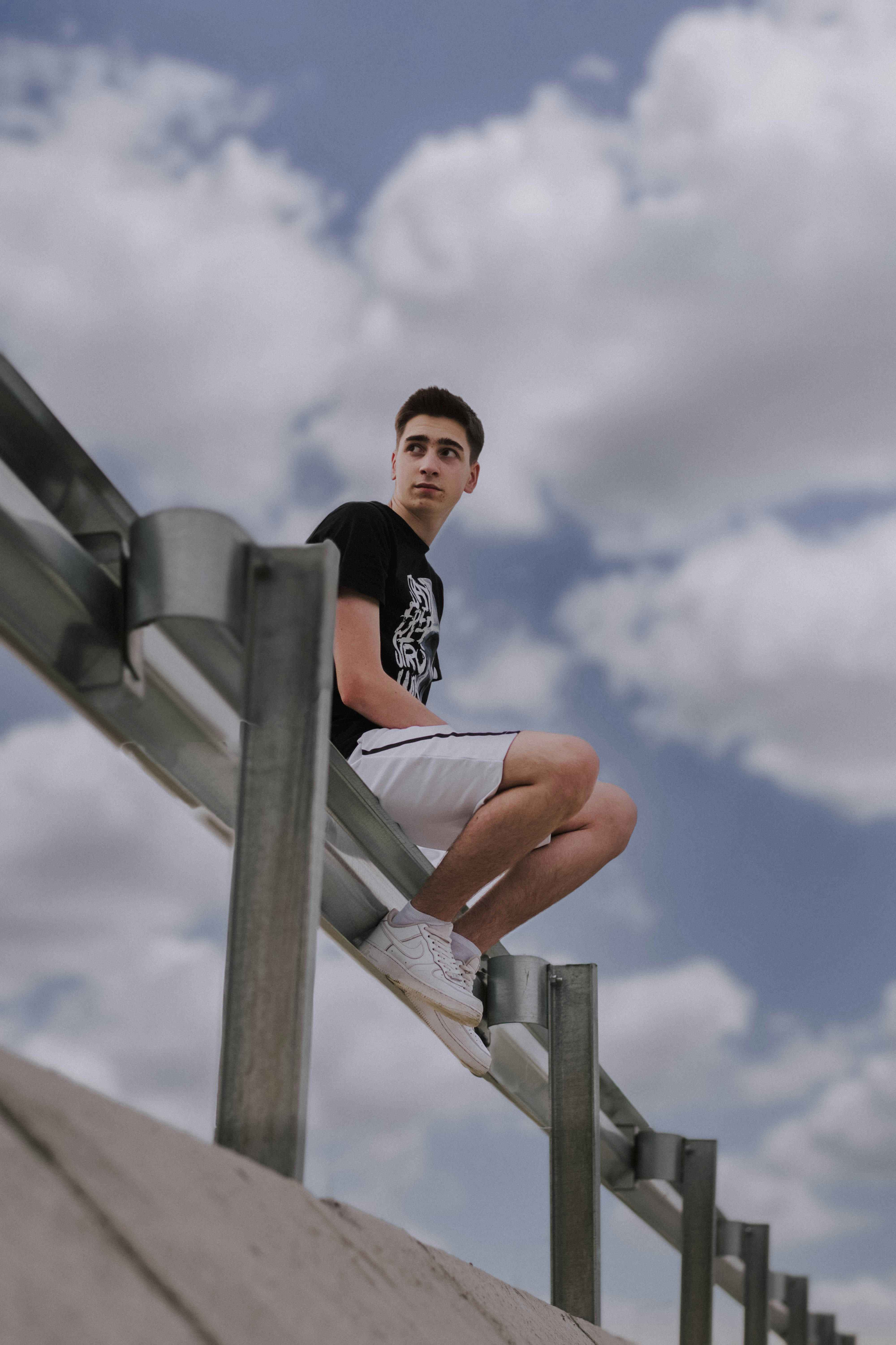 A man sitting on a railing photo – Free Human Image on Unsplash