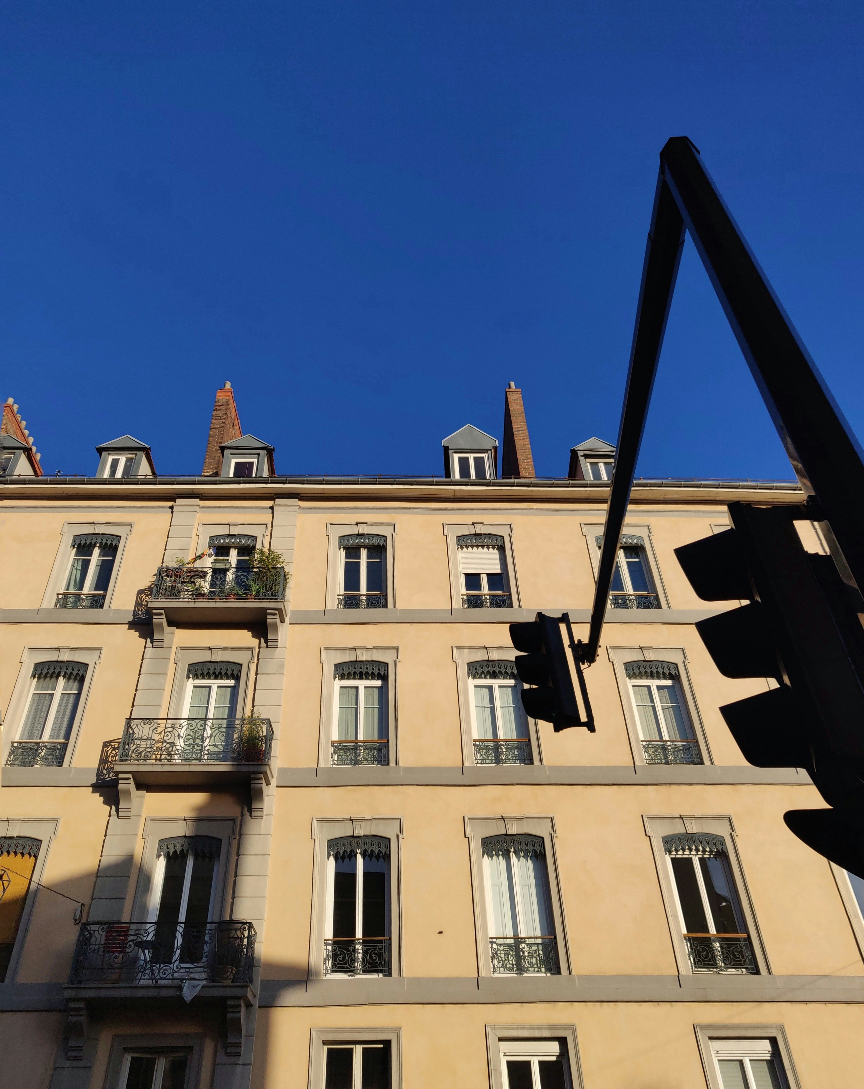 Iron Arrow Framing a Sunlit Parisian Facade