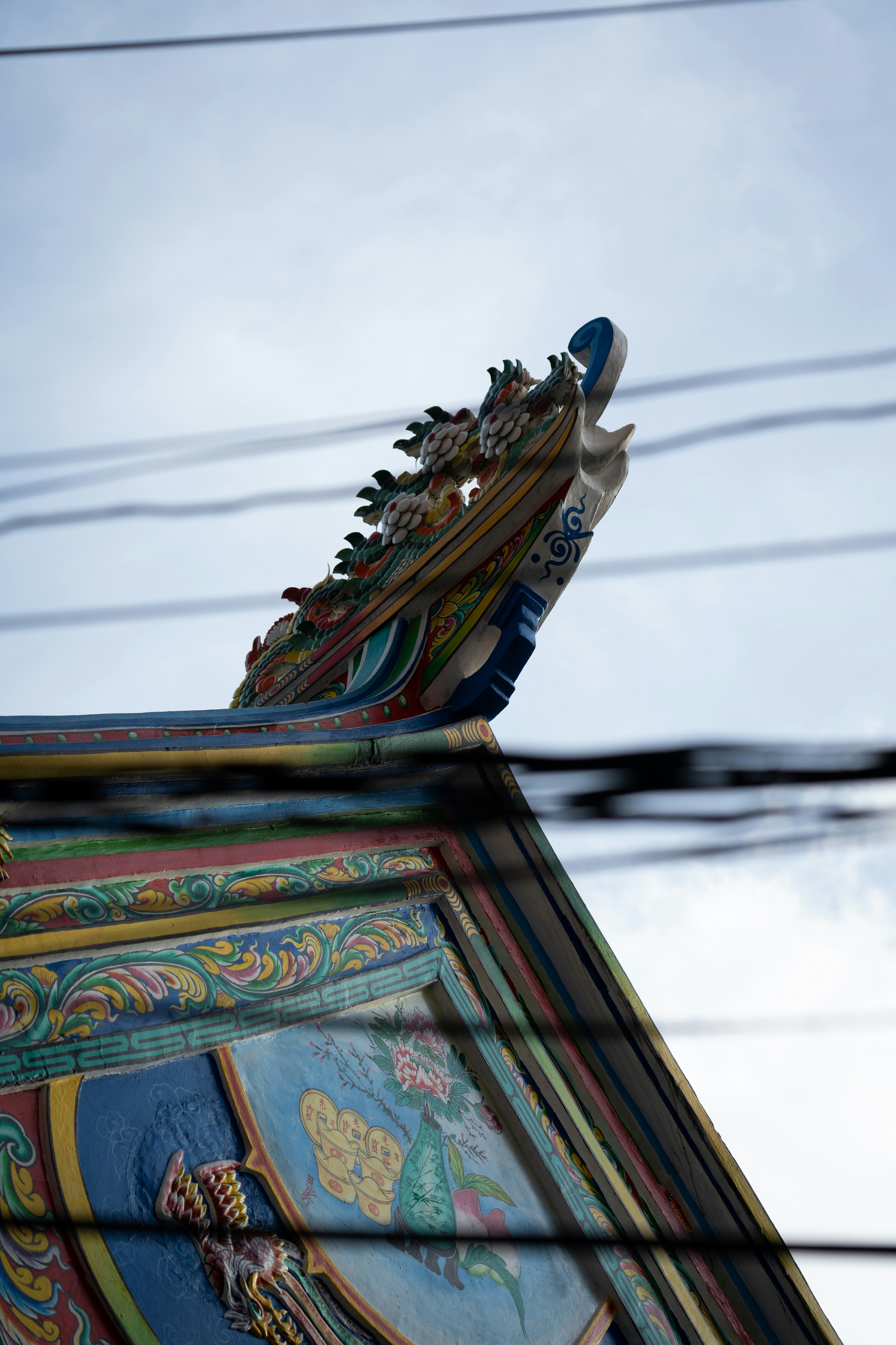 Ornate Roof Crest Sliced by Wires and Sky