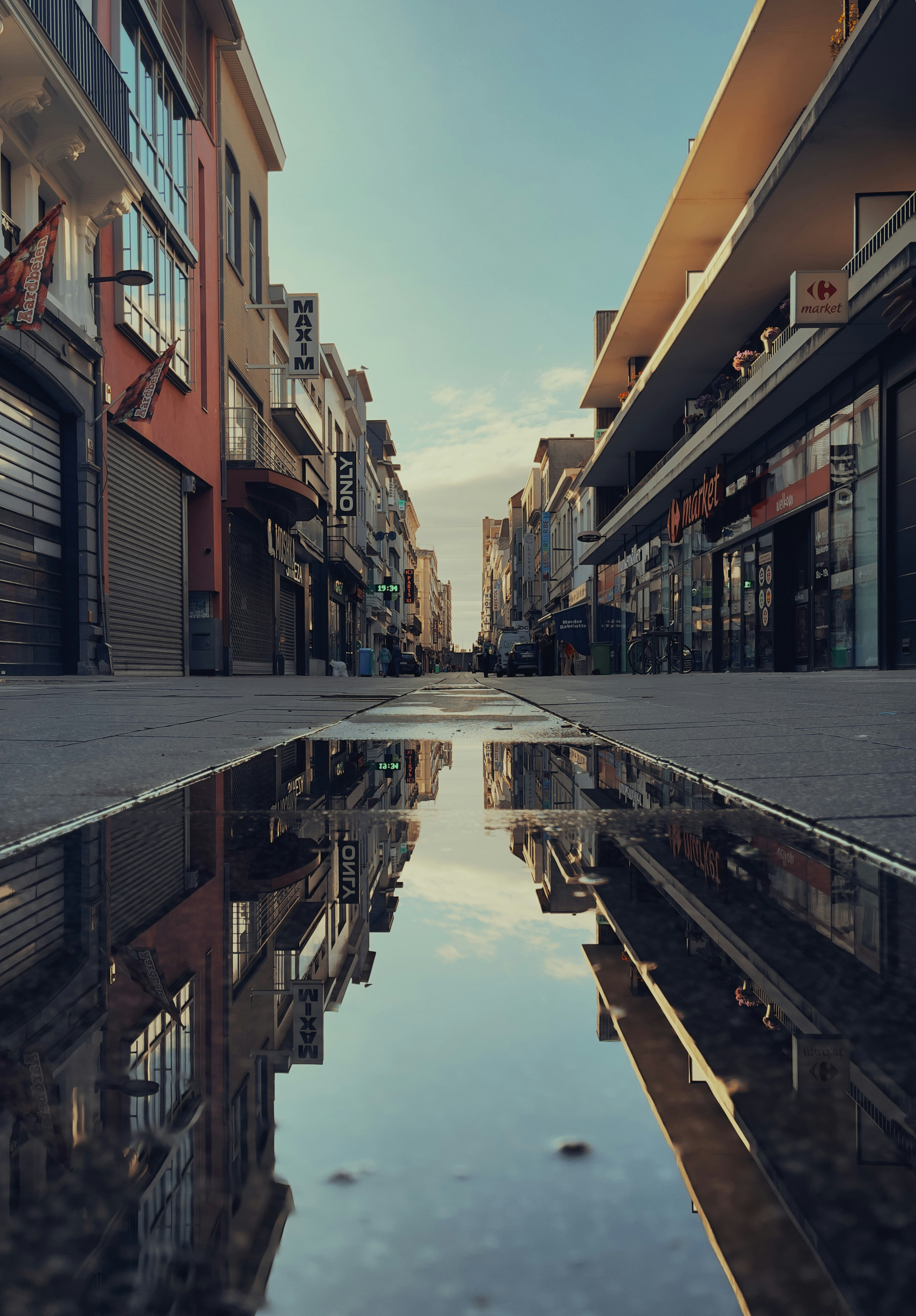 Eye-Level Reverie: The Street Reflected in a Quiet Puddle