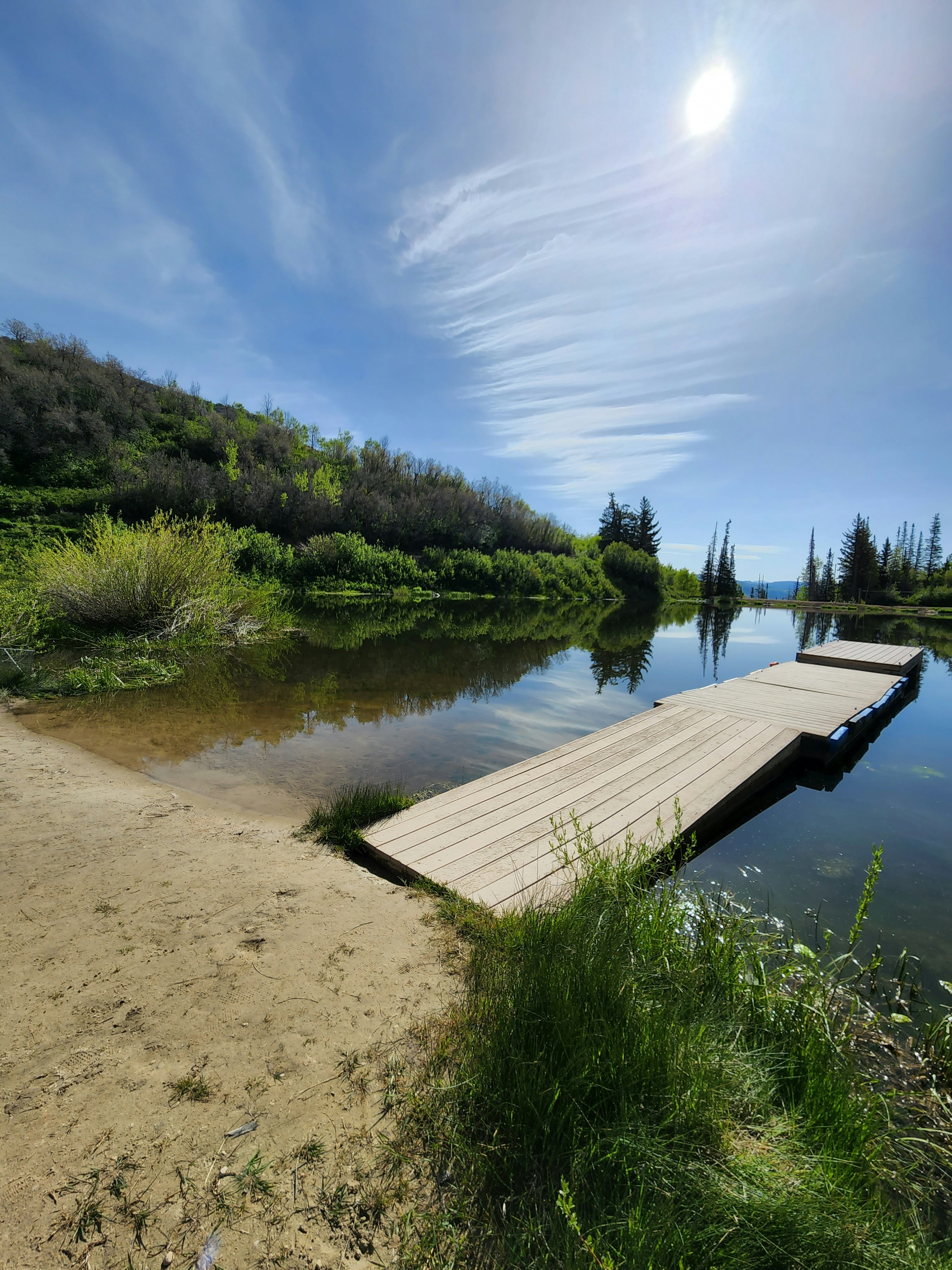 Sunlit Dock Reaches Across a Quiet Alpine Lake