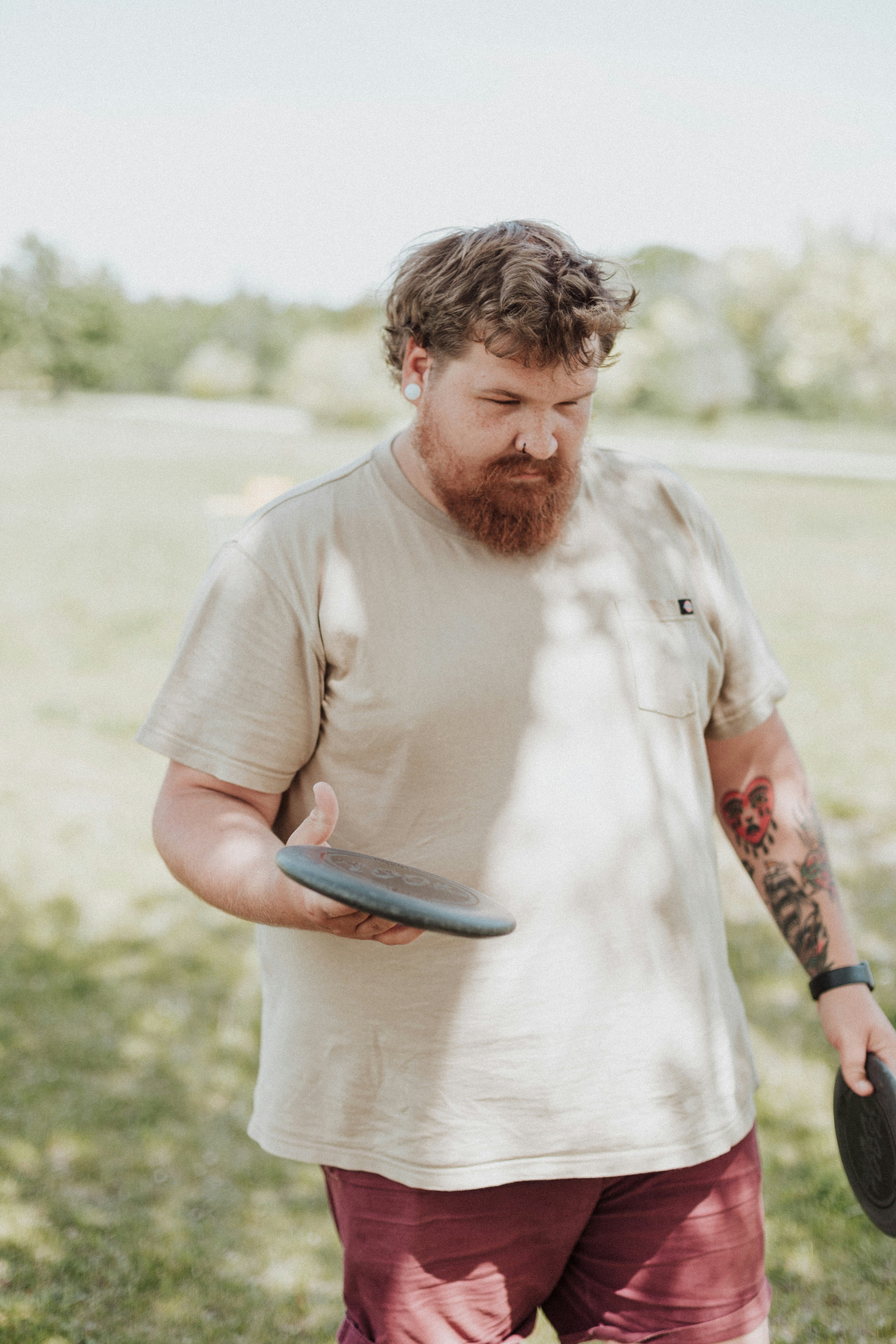 Two Discs in the Sun: A Bearded Disc Golfer in a Quiet Park