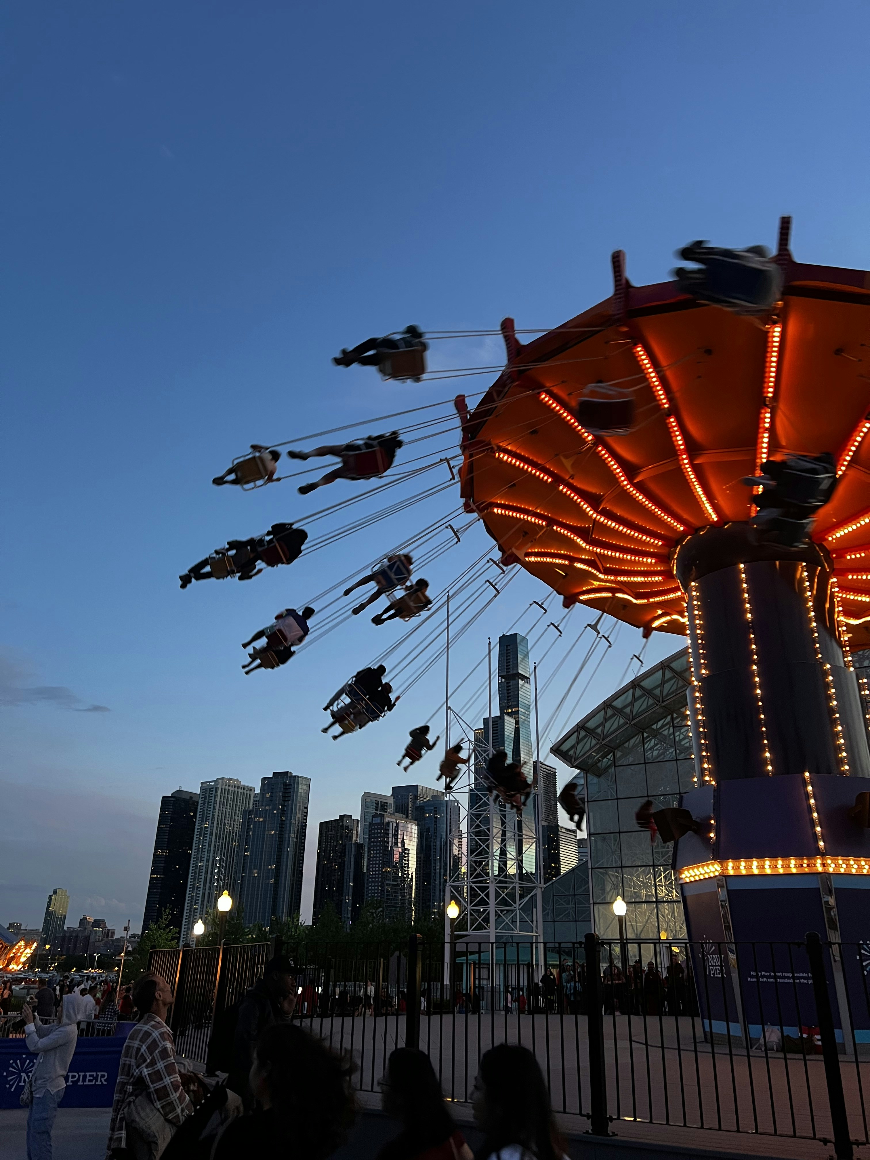 Dusk Carousel: Neon Rings Framing a Modern City Silhouette