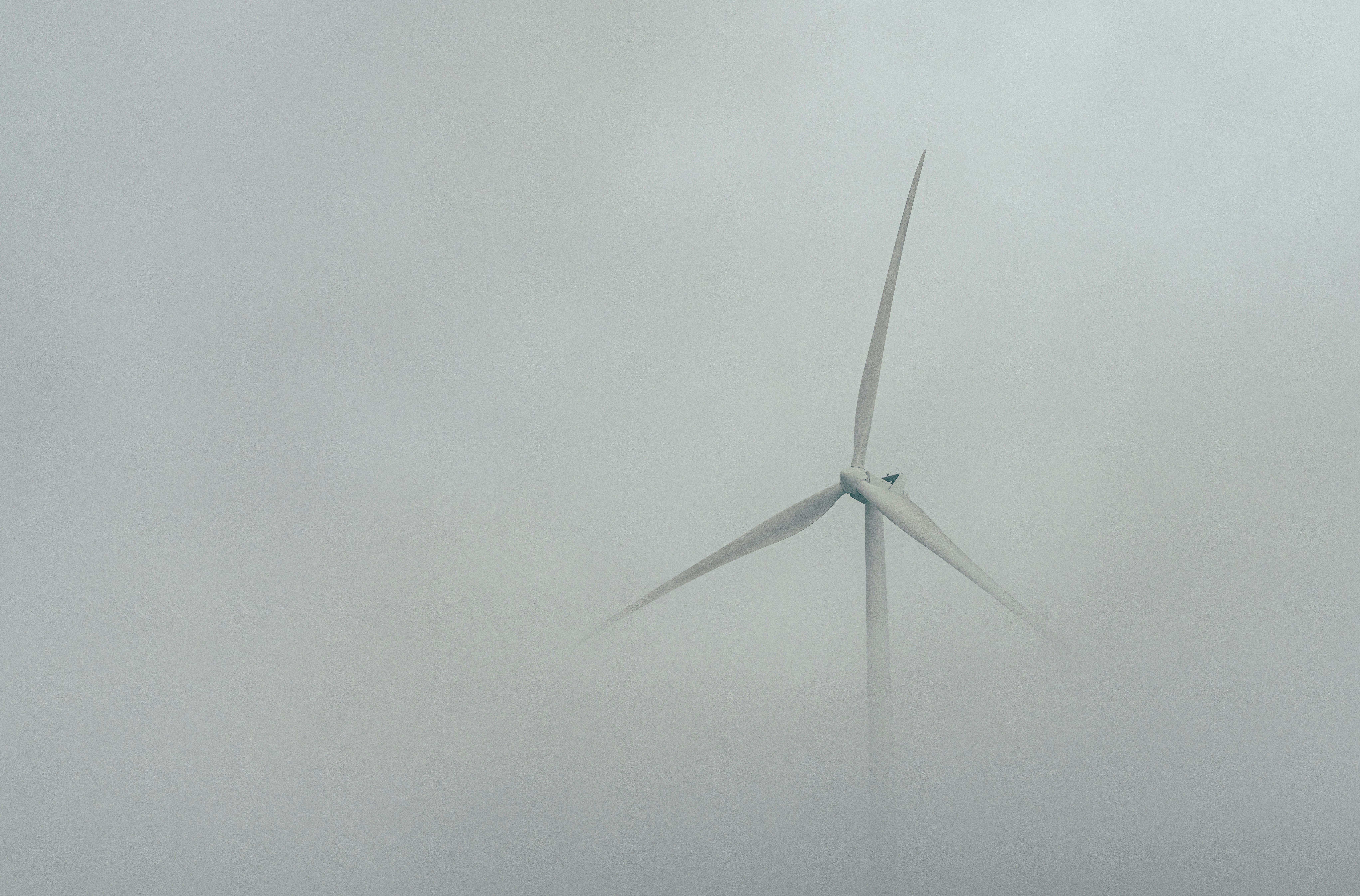 A wind turbine in the middle of a grey sky photo – Free Wallpaper Image ...
