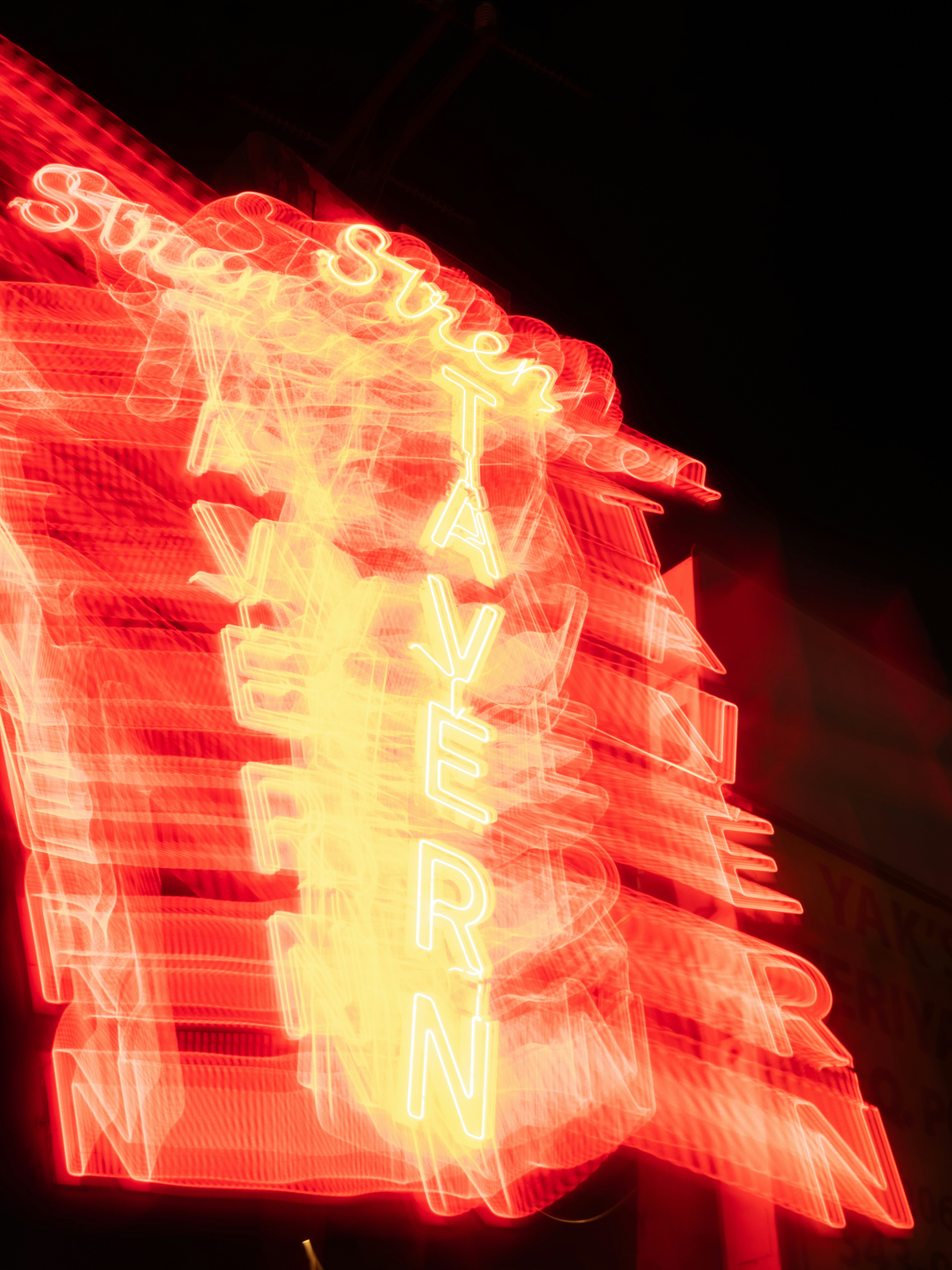 Crimson Neon Echoes: Long-Exposure Blur of a Sign
