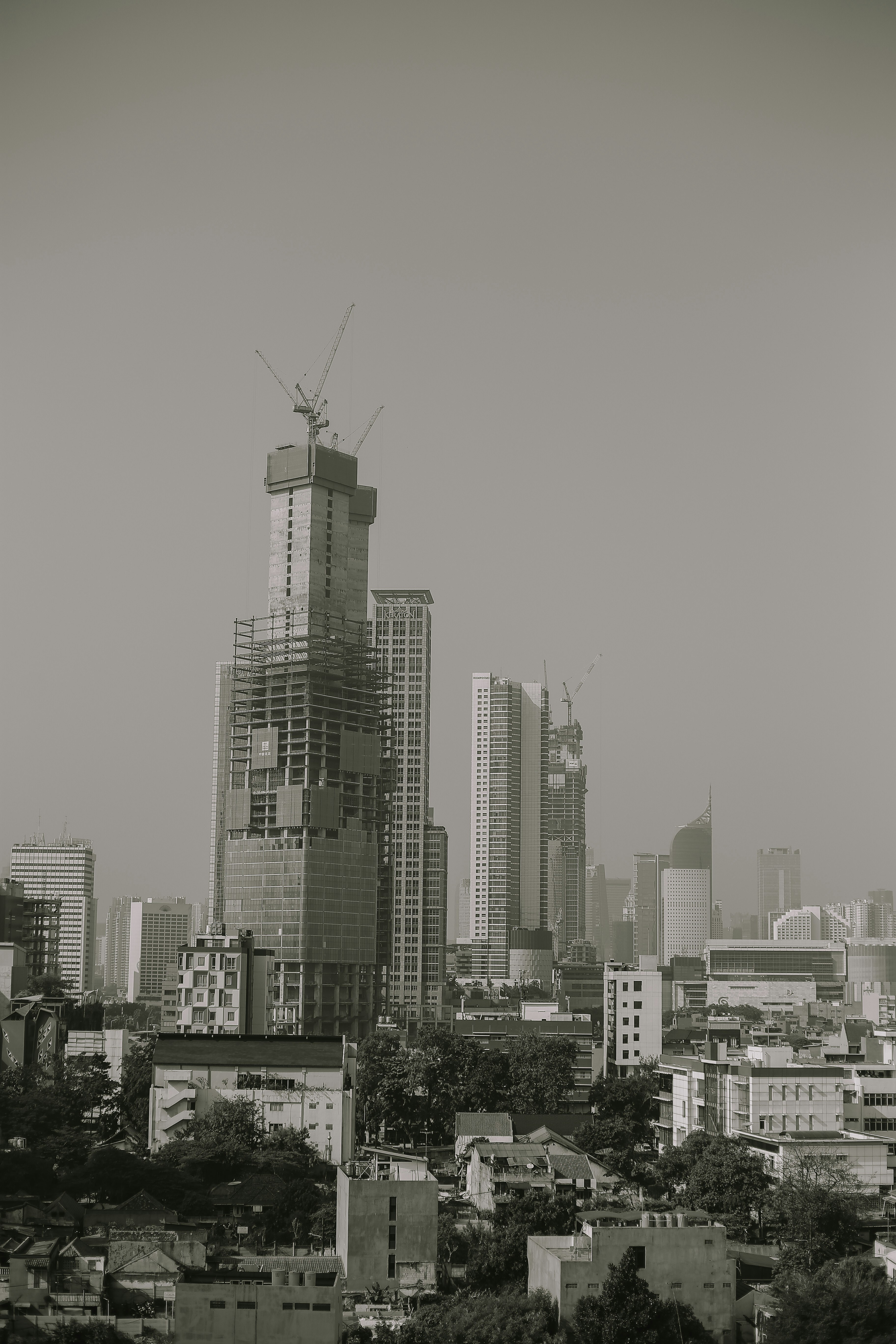 Crane Crowned Tower: A Sepia Cityscape Rises
