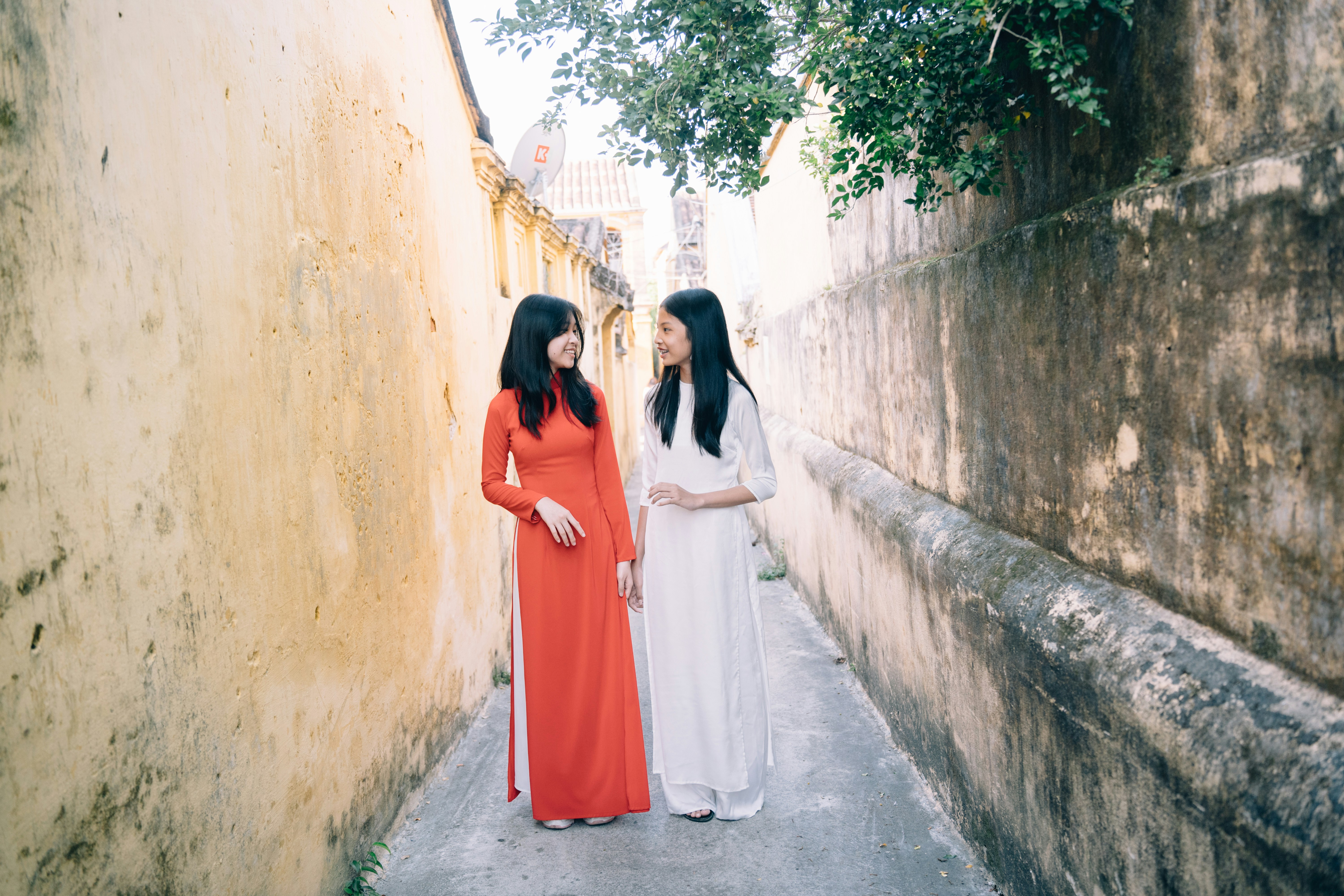 Foto Dos mujeres vestidas de pie en una calle estrecha – Imagen Ropa ...