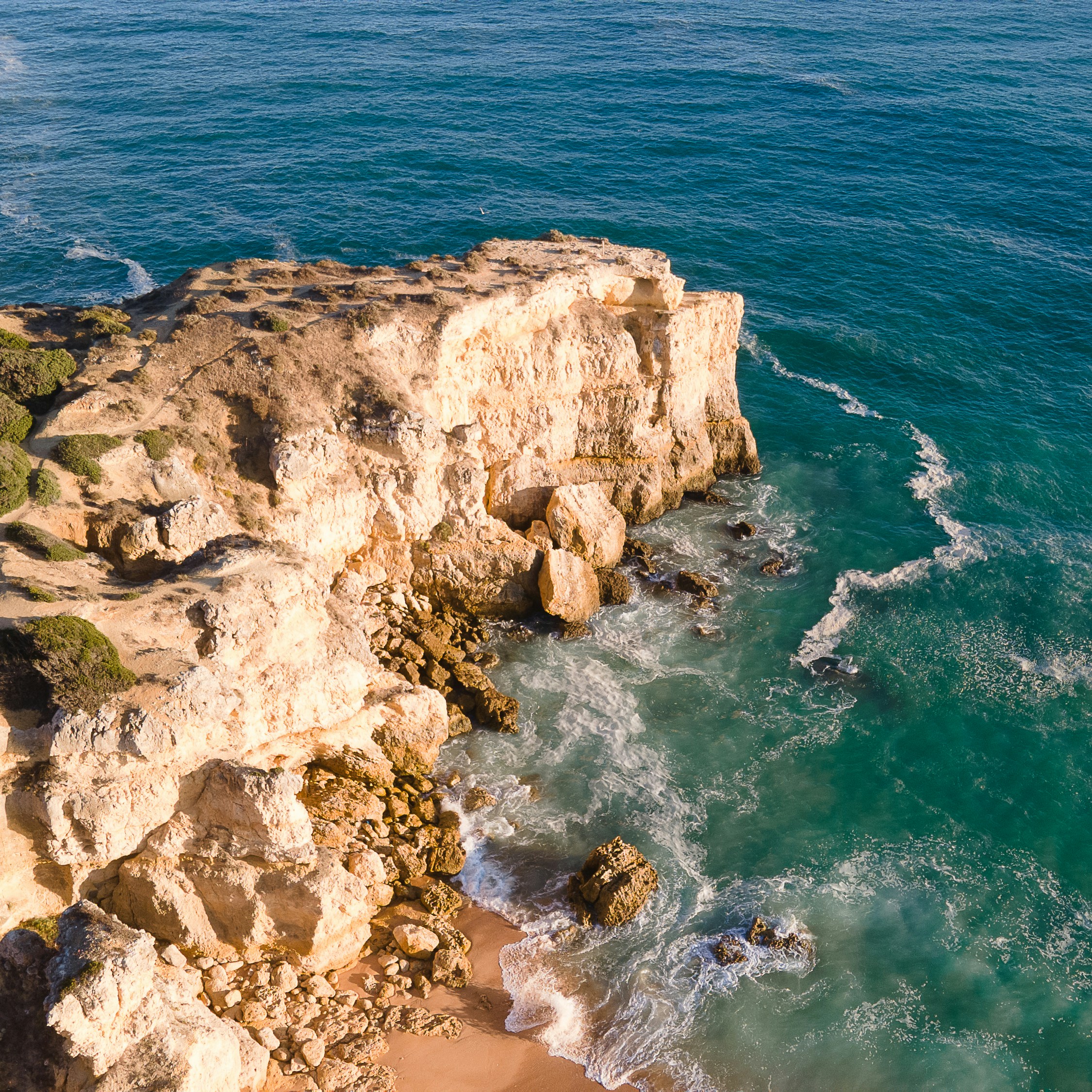 A rocky cliff with waves crashing against it photo – Free Cliff Image ...