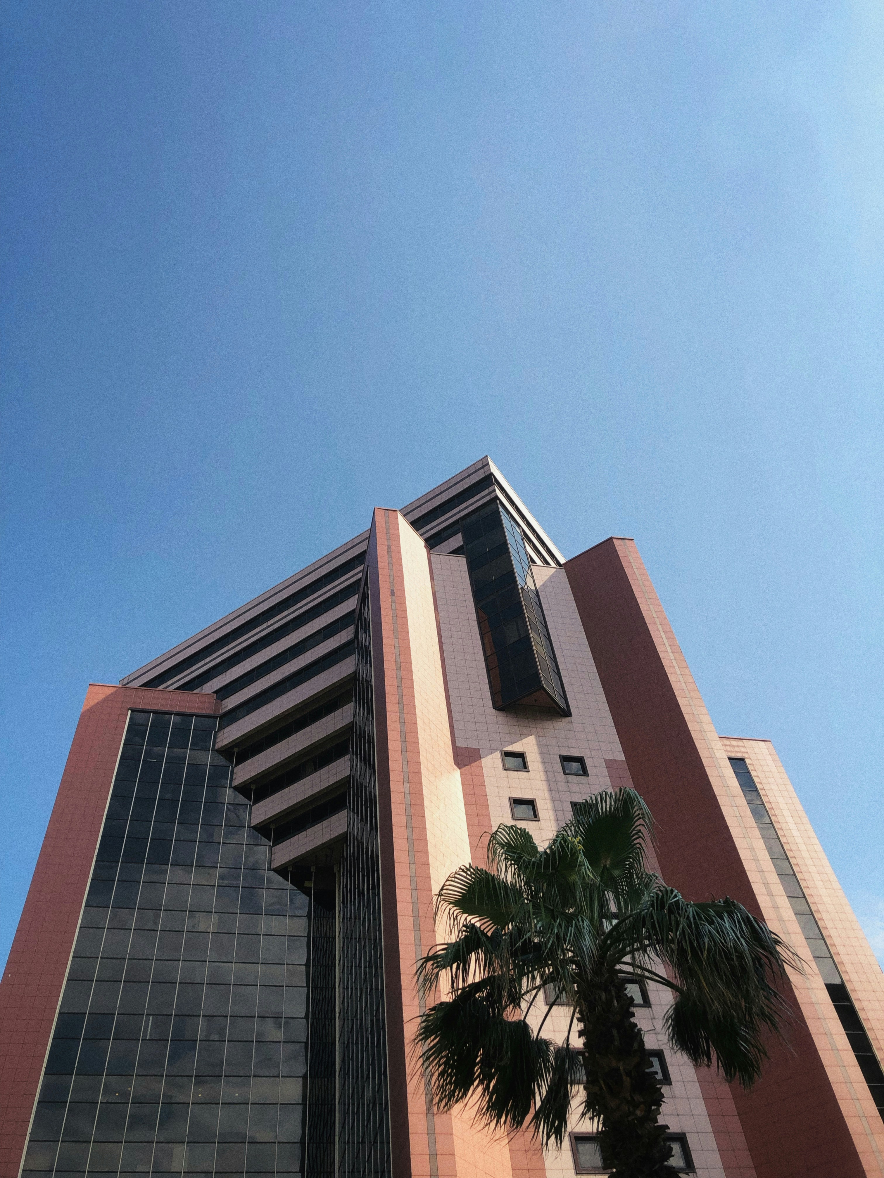 Skyward Facade: A Modern Tower Ascending Against a Pristine Blue Sky