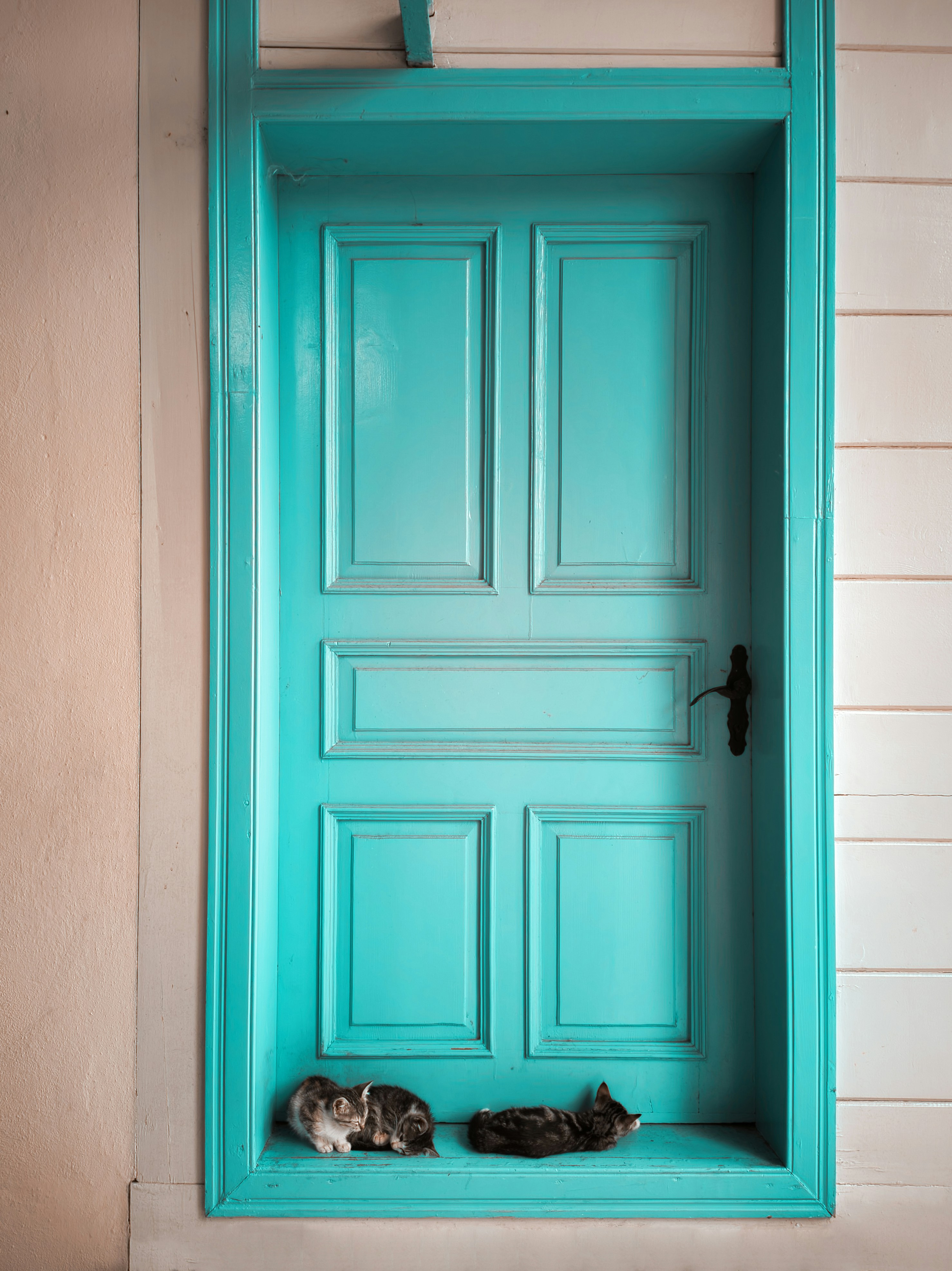 Teal Doorway Beneath a Quiet Balcony