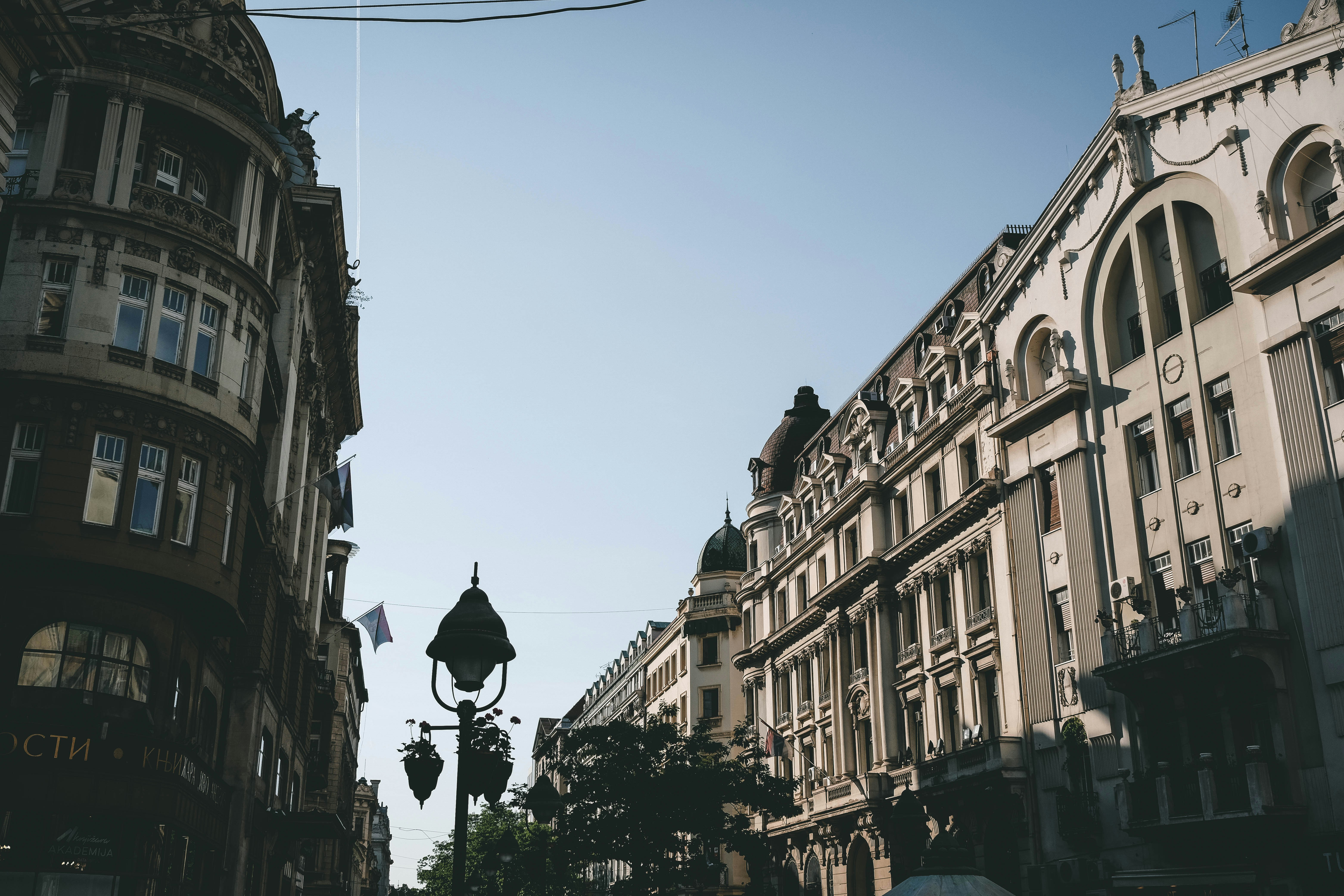 Historic buildings lining a city street under a clear blue sky.