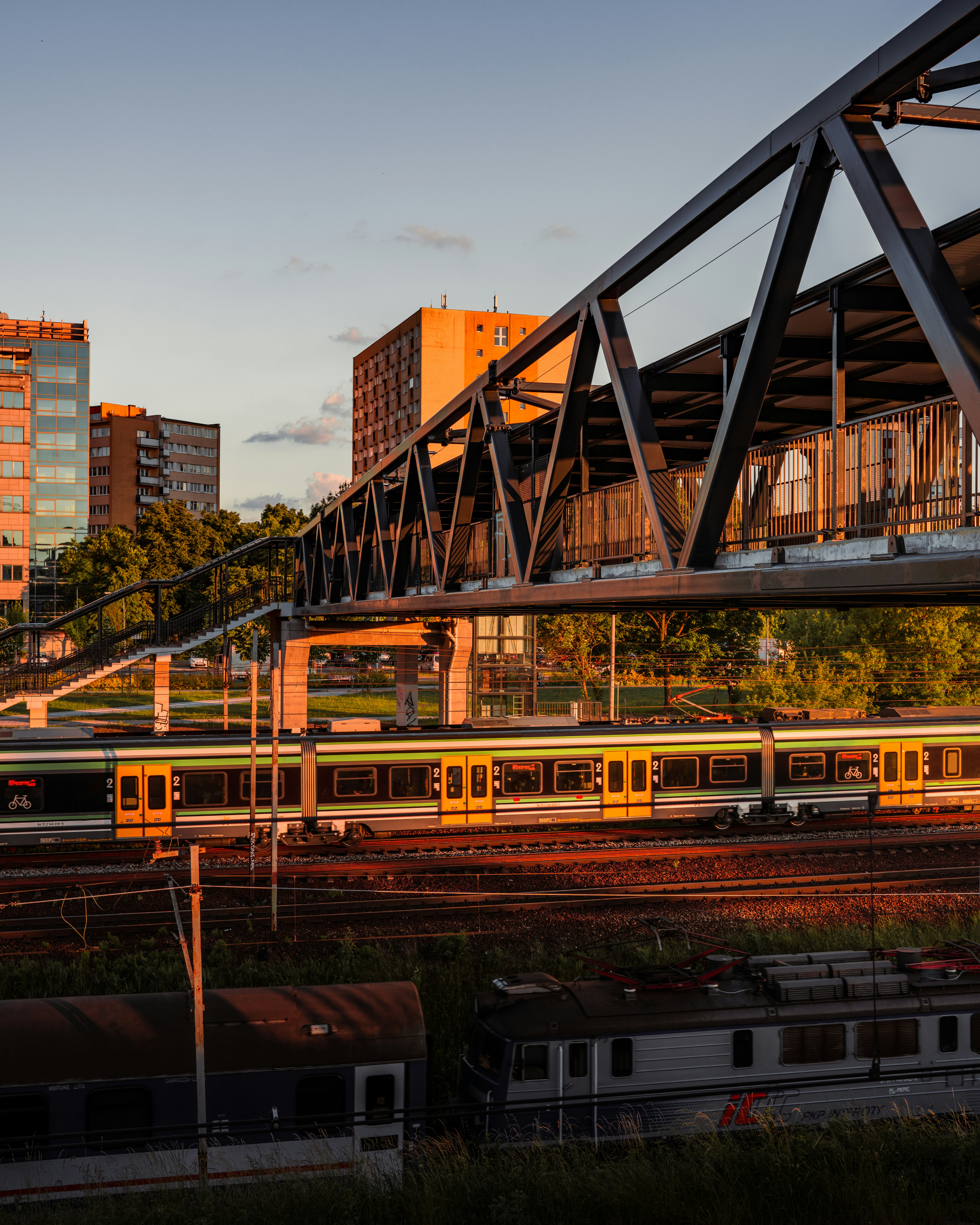 Sunset Over the Tracks: A Rail Bridge and Train in Warm Light