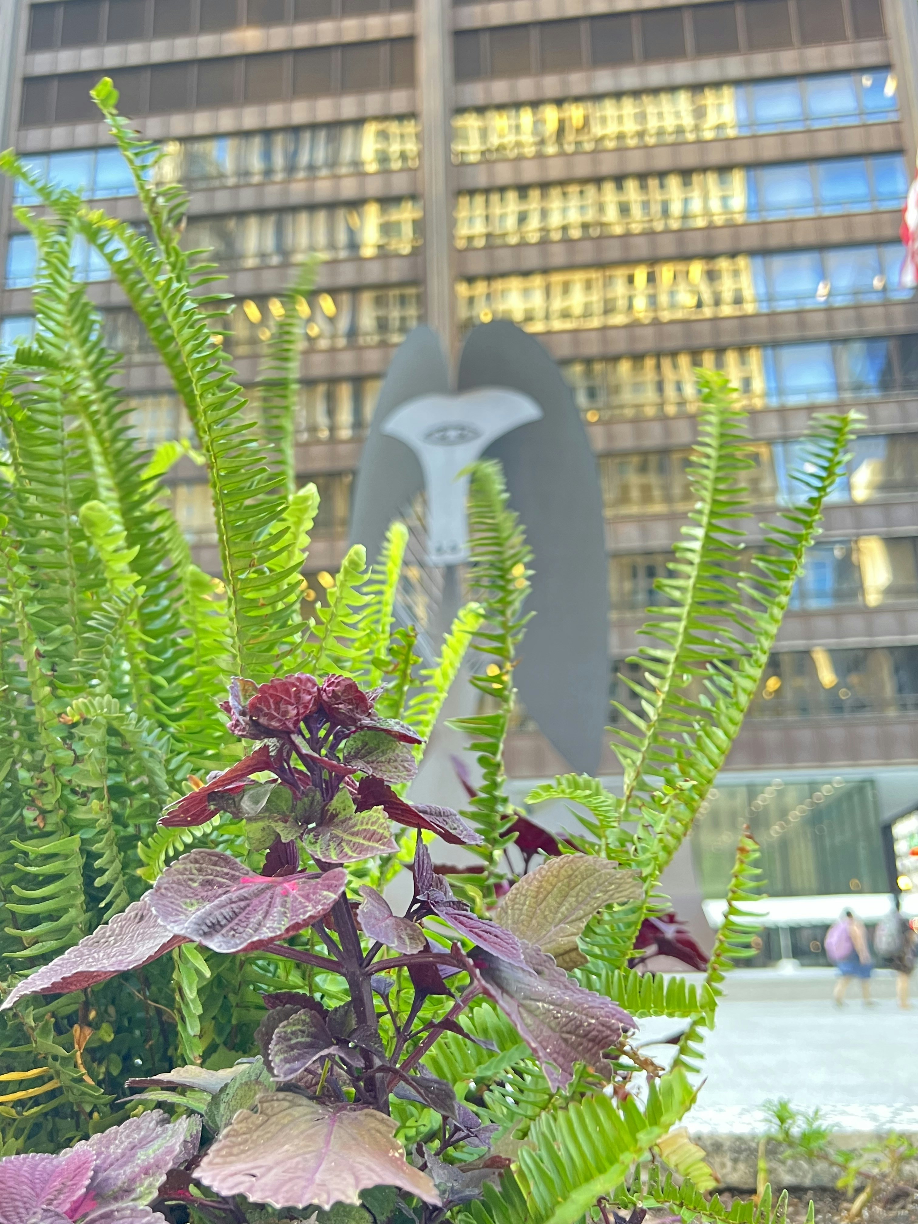 Urban planter in front of glassy corporate facade with a sculptural centerpiece