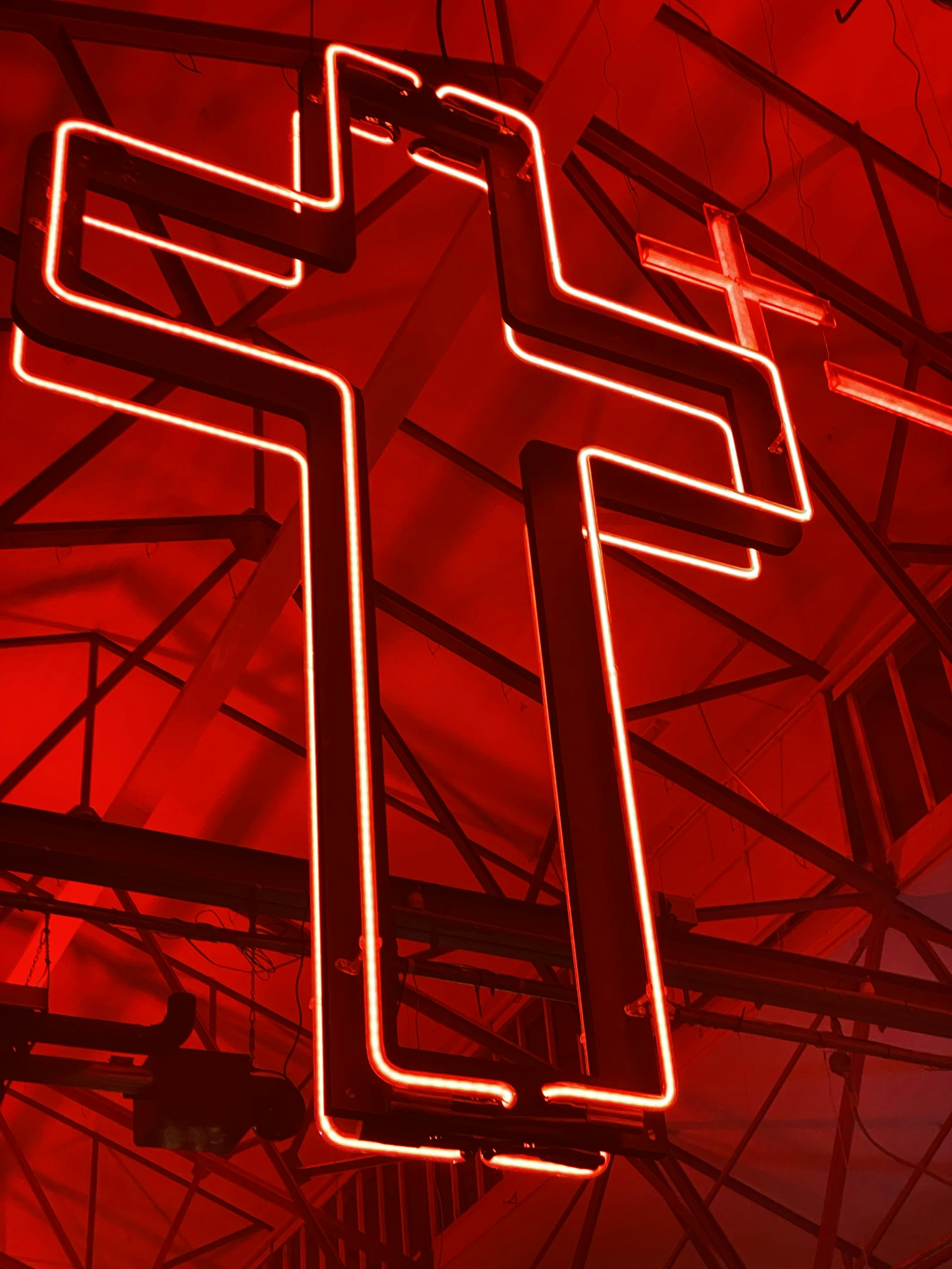 Crimson Neon Crosses Over an Exposed Industrial Ceiling