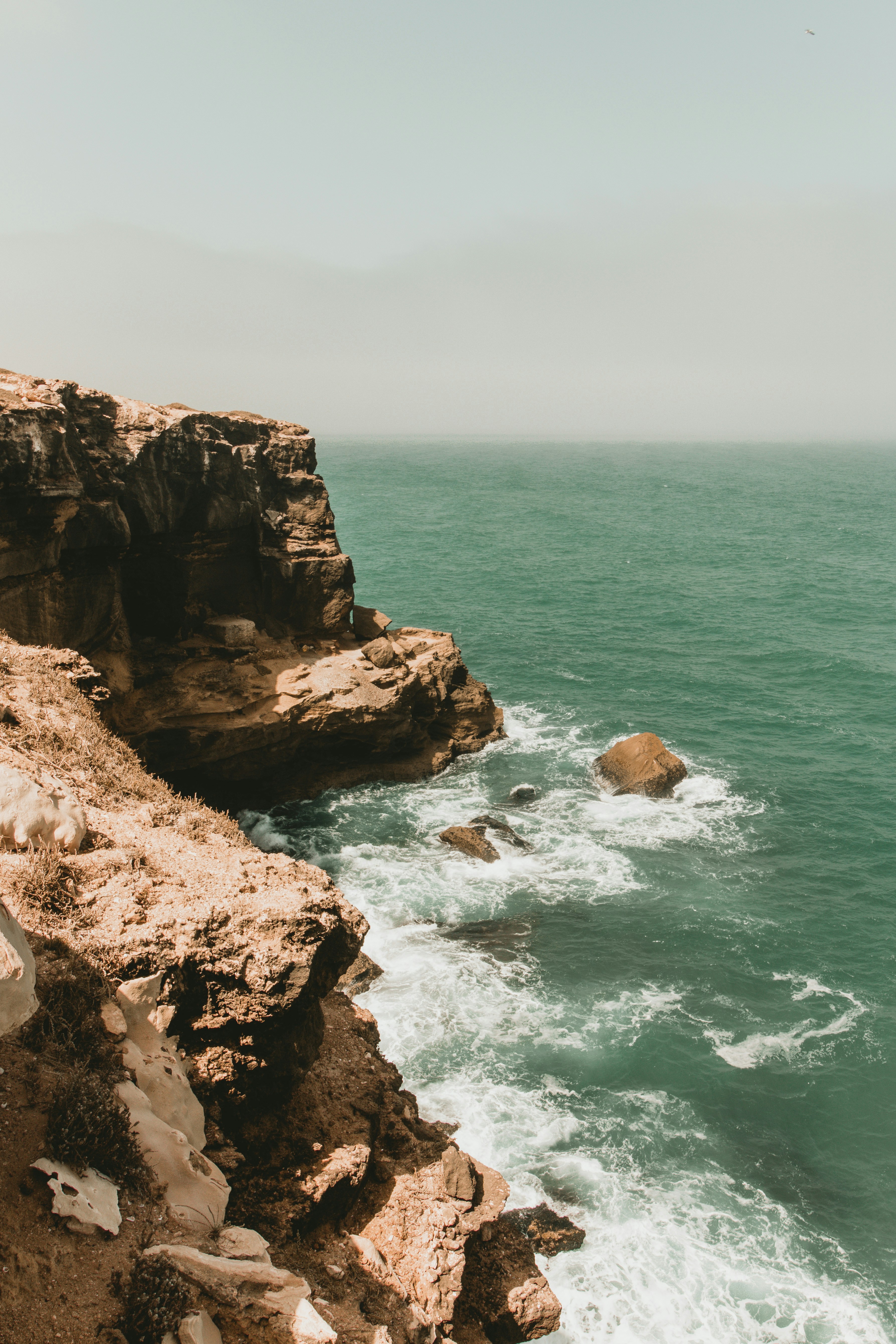 A rocky cliff next to the ocean photo – Free Morocco Image on Unsplash