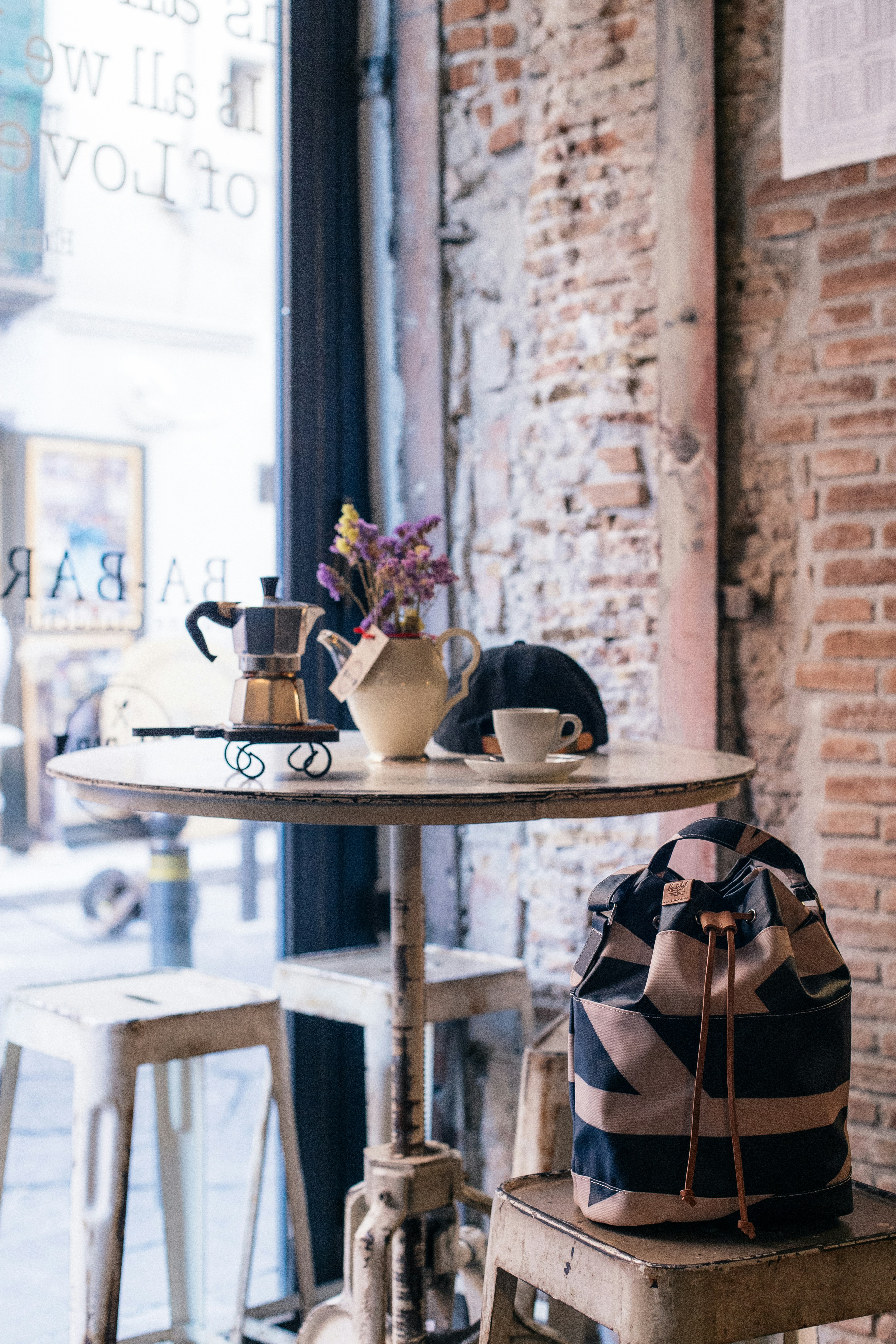 Steam and Stripes: A Café Table Composition with Moka Pot, Vase, and Backpack