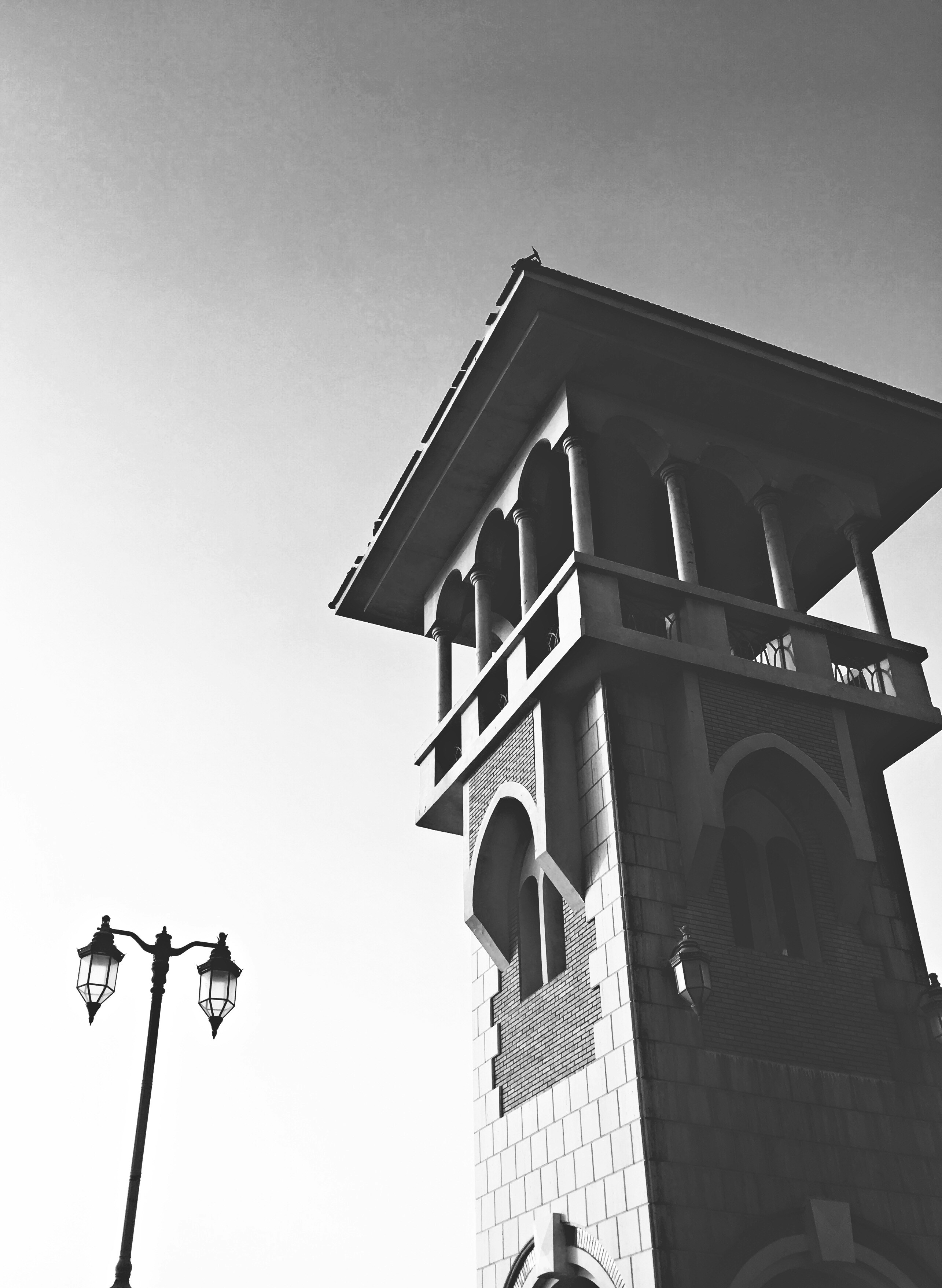 Monochrome Reach: Brick Tower Against a Pale Sky